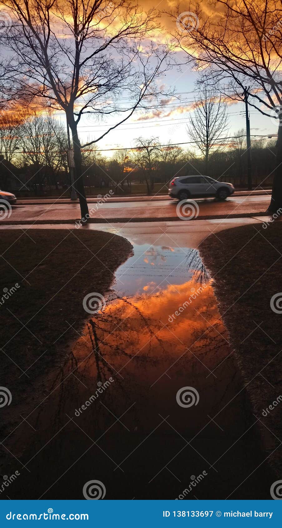 Puddle sunset reflections stock image. Image of road - 138133697