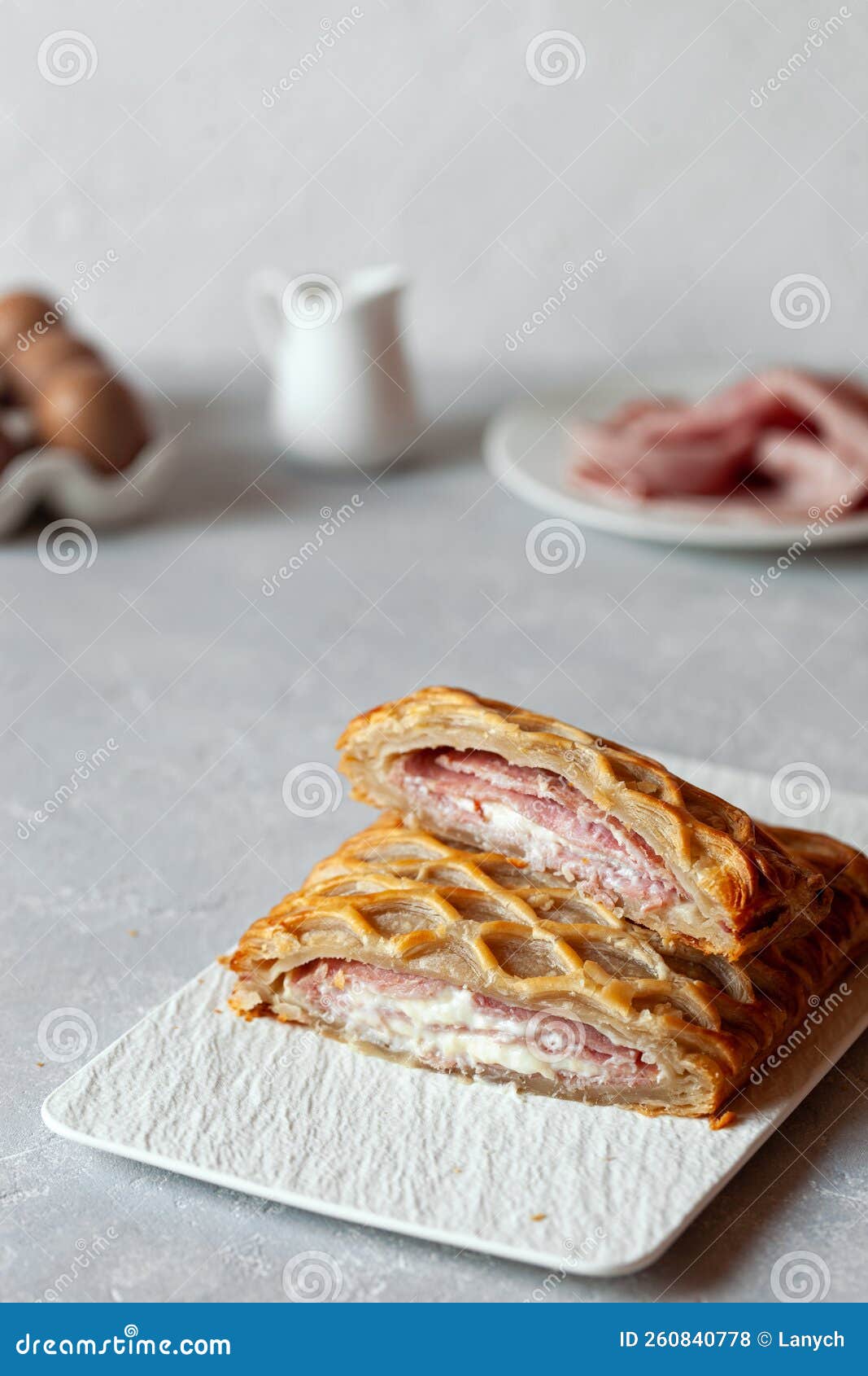 Puff with Ham and Cheese Cut on a Rectangular Plate on a Kitchen Table ...