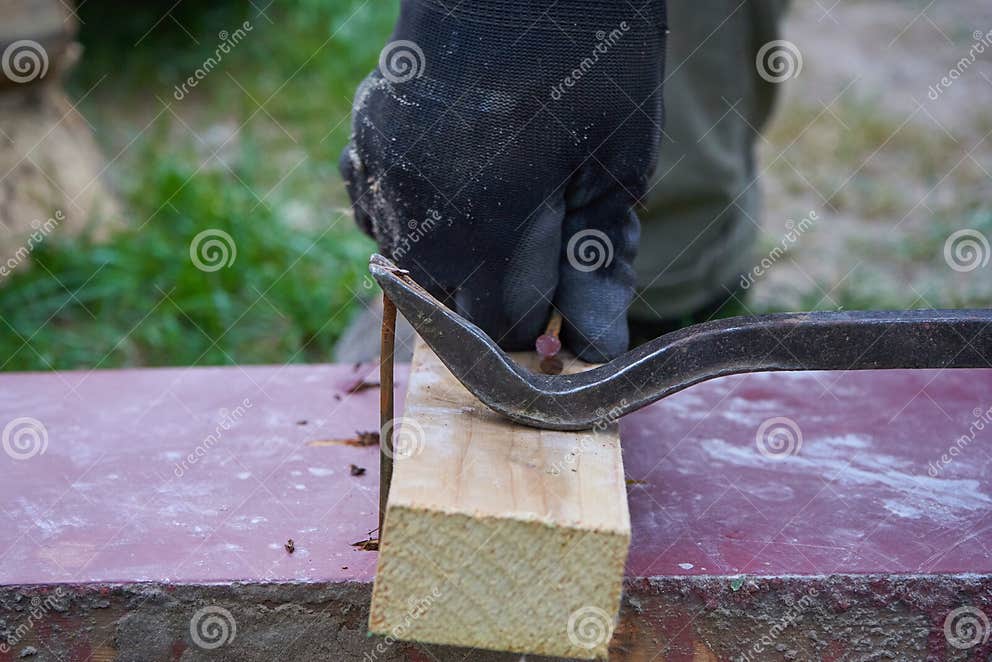 Pull Out Crowbar Nails, a Nail Puller Pulls a Nail Out of the Board ...