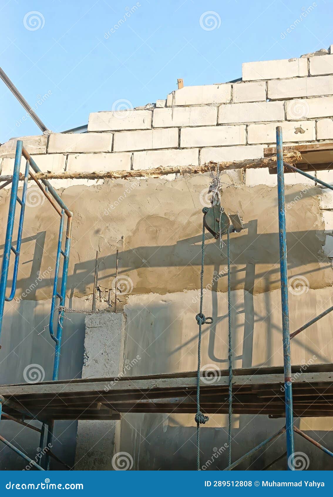 A Pulley Lifting Goods Up a Construction Building Stock Photo - Image ...