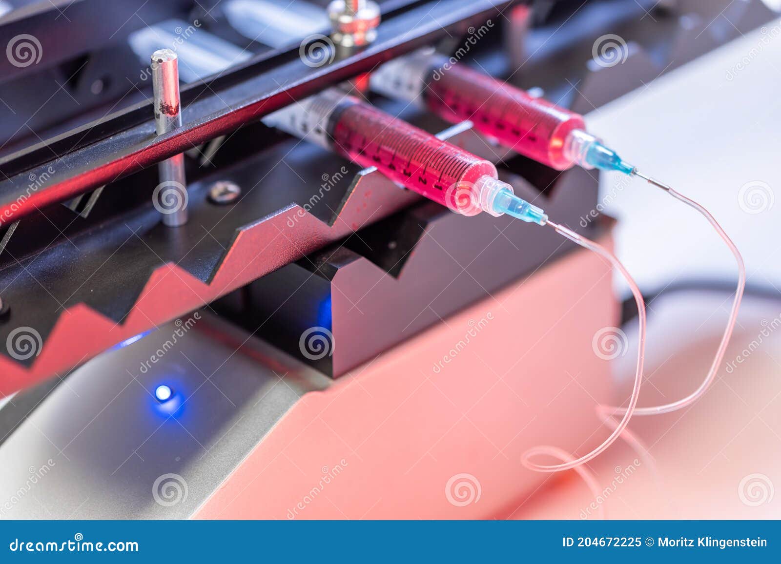 Pump Pushing Red Liquid Medium through Syringes and Flexible Tubes in a ...