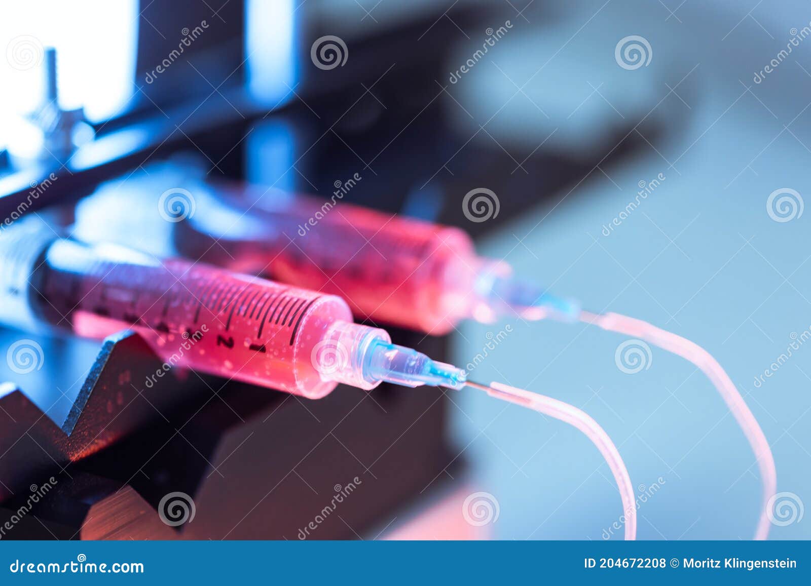 Pump Pushing Red Liquid Medium through Syringes and Flexible Tubes in a ...