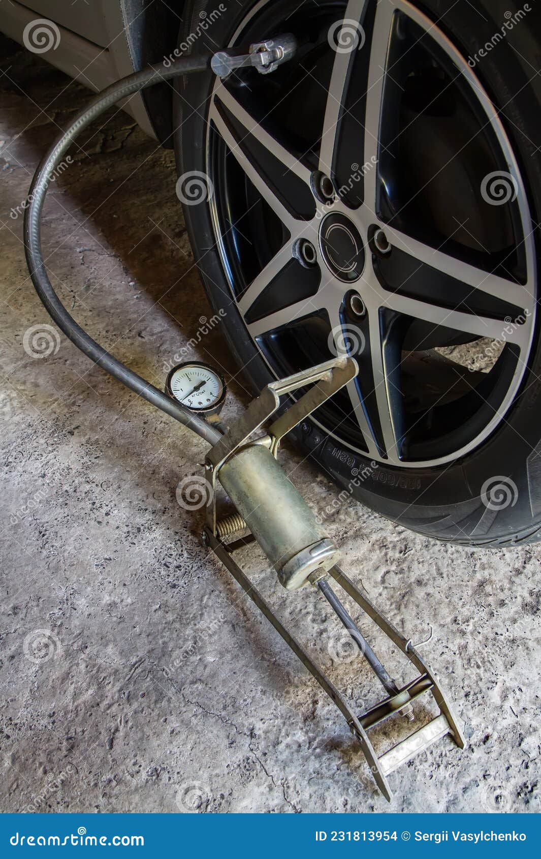Pumping the Wheel of the Car with the Help of a Foot Pump. Stock Photo ...