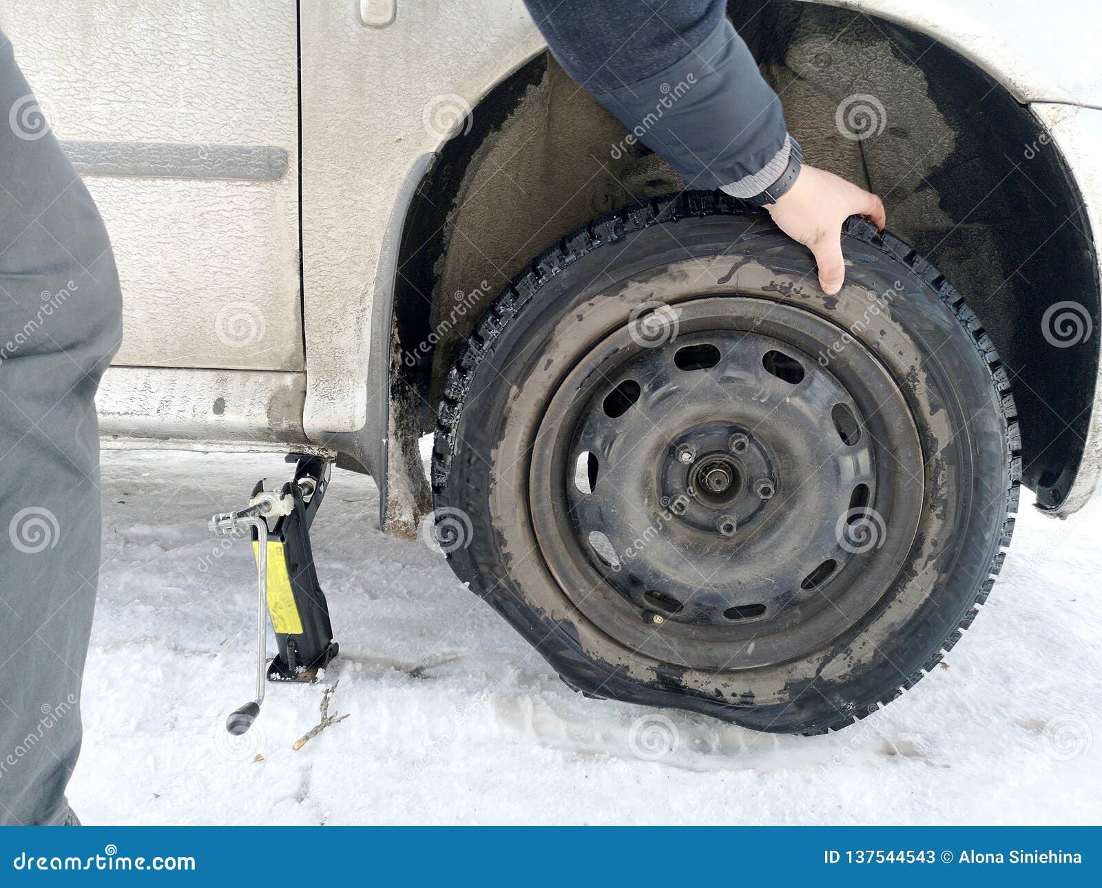 Punched and Flat Tire on the Road. Replacing the Wheel with a Jack by ...