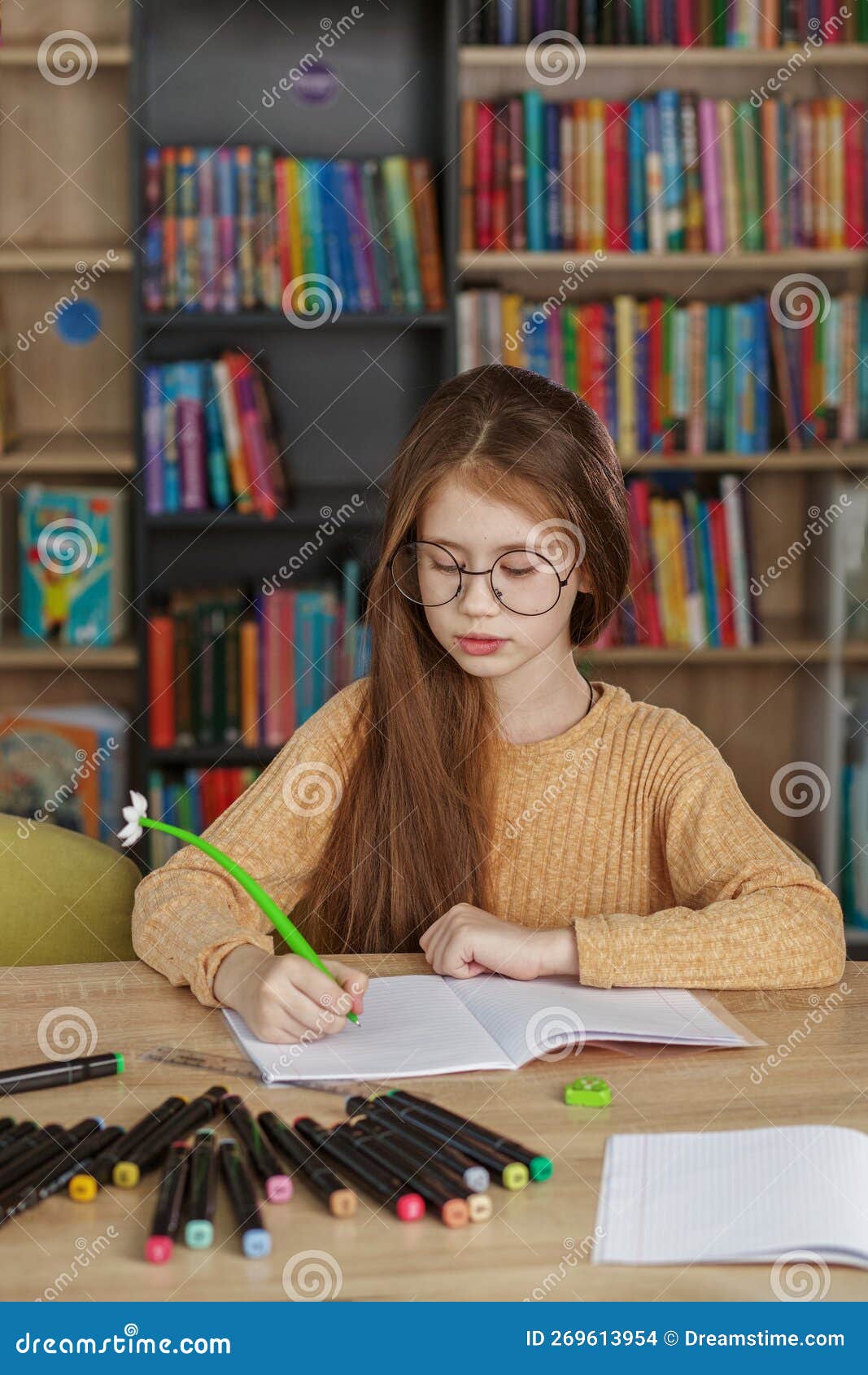 Pupil Learning in School. Girl Writes in Copybook and Does Homework ...