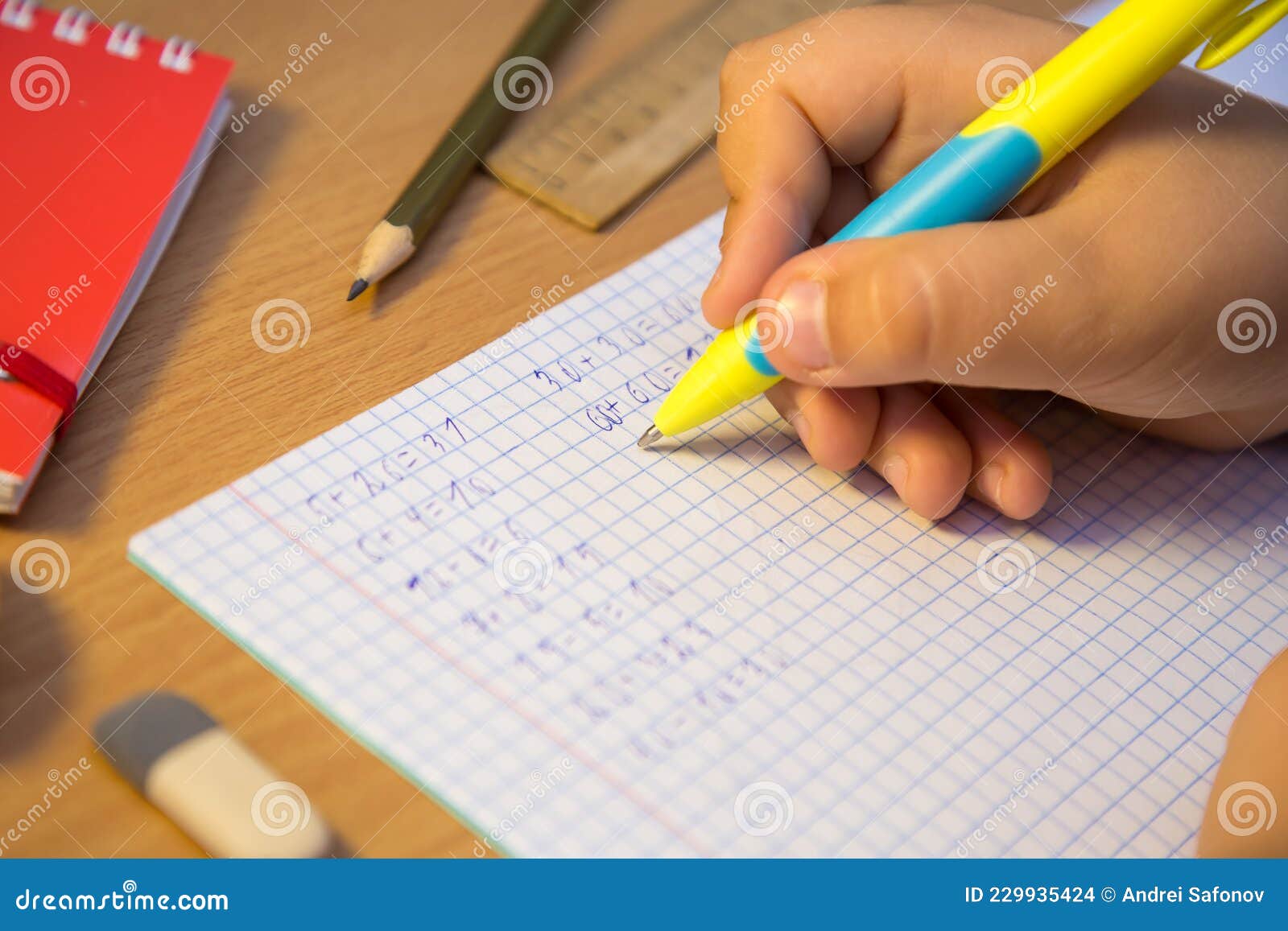 Pupil S Hand Solves Math Examples with a Ballpoint Pen Close-up. Stock ...