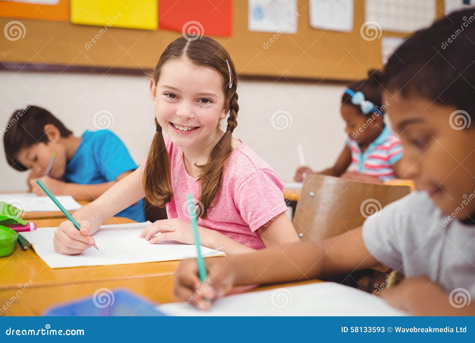 Pupil working at her desk stock image. Image of preschool - 58133593