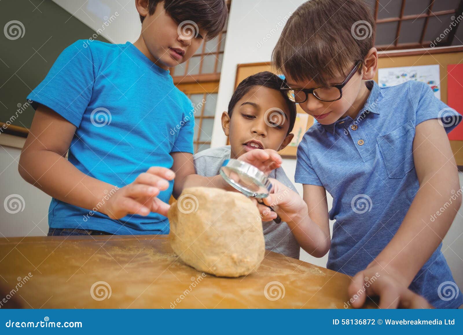 Pupils Looking at Rock with Magnifying Glass Stock Photo - Image of ...
