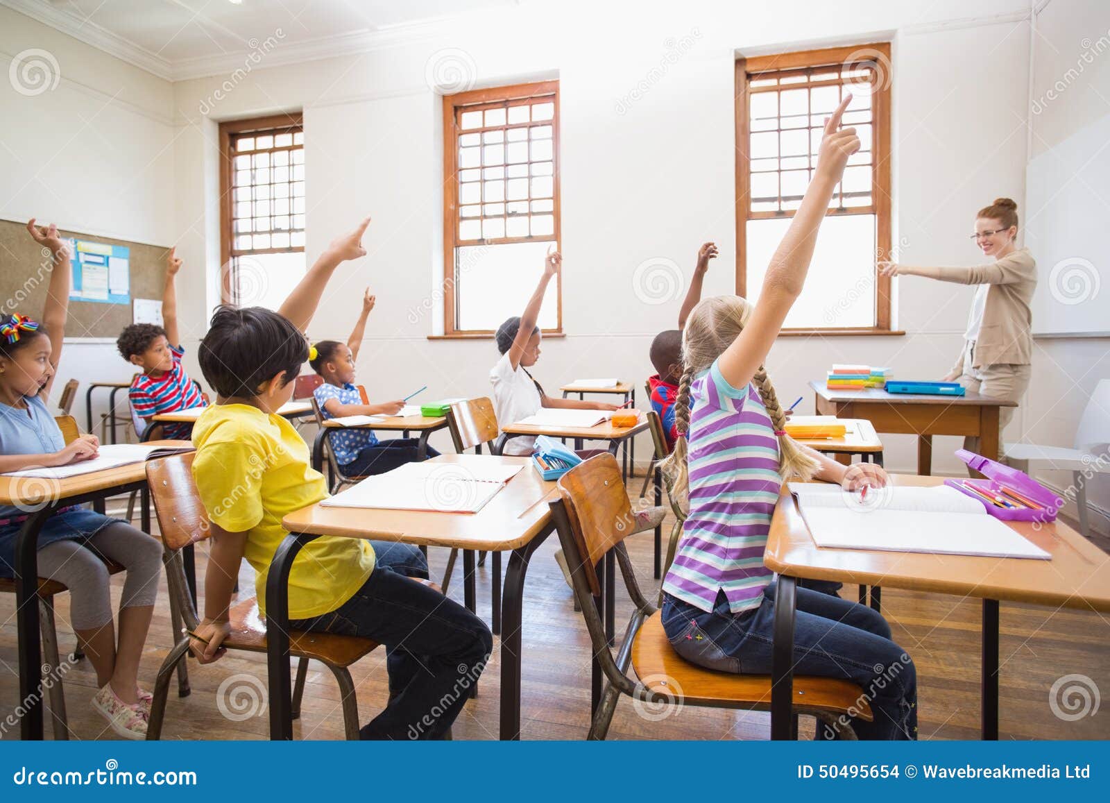 Pupils Raising Hand in Classroom Stock Photo - Image of elementary ...