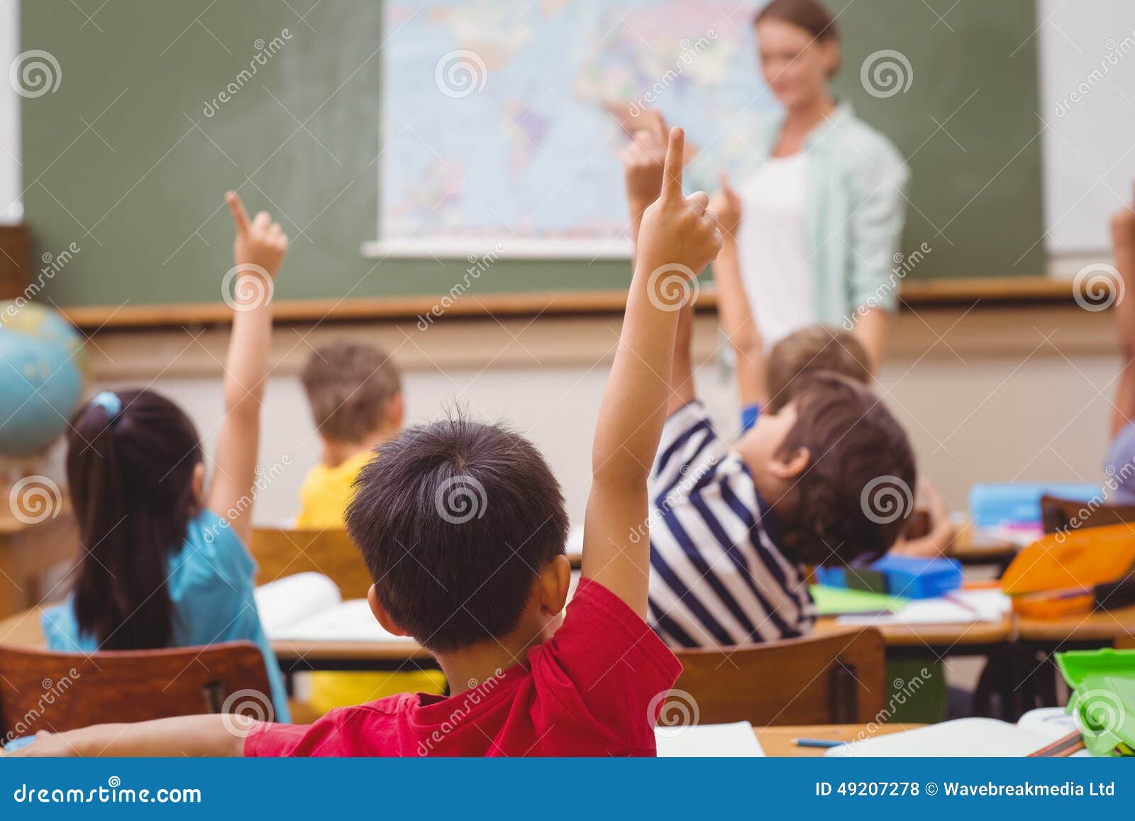 Pupils Raising Hand during Geography Lesson in Classroom Stock Photo ...