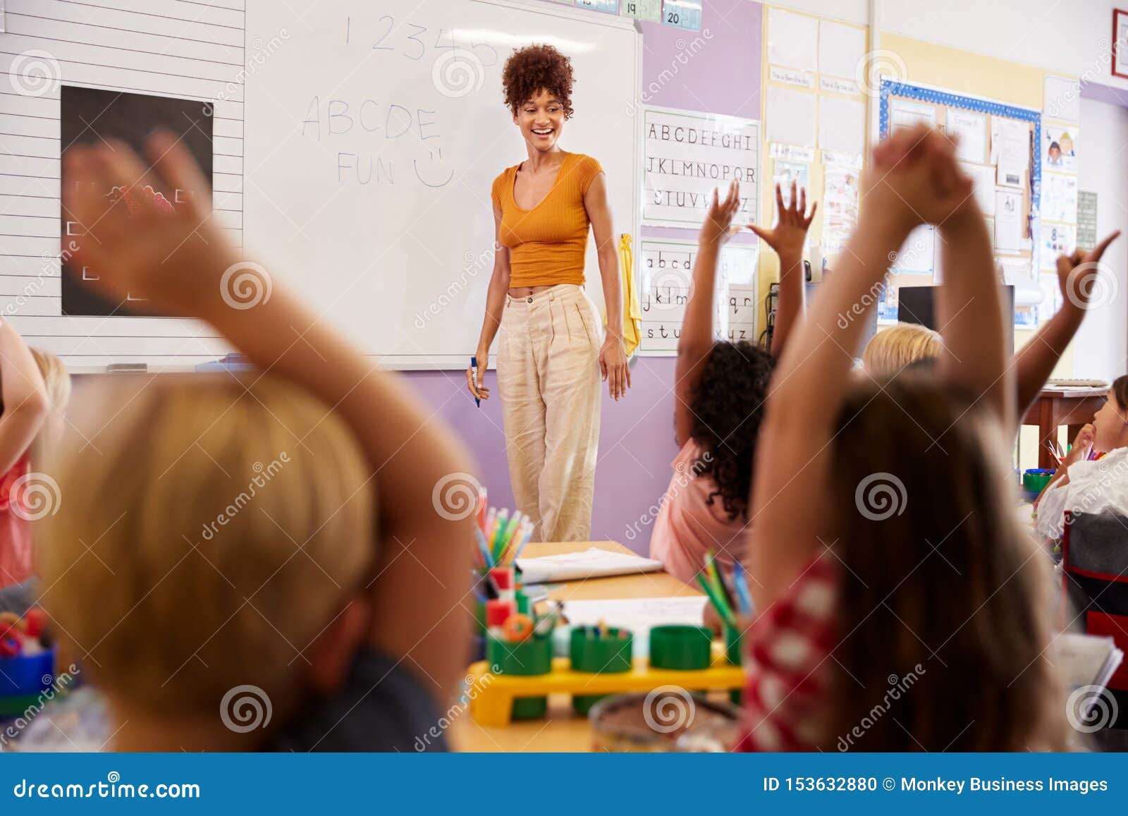 Pupils Raising Hands To Answer Question in Elementary School Maths ...