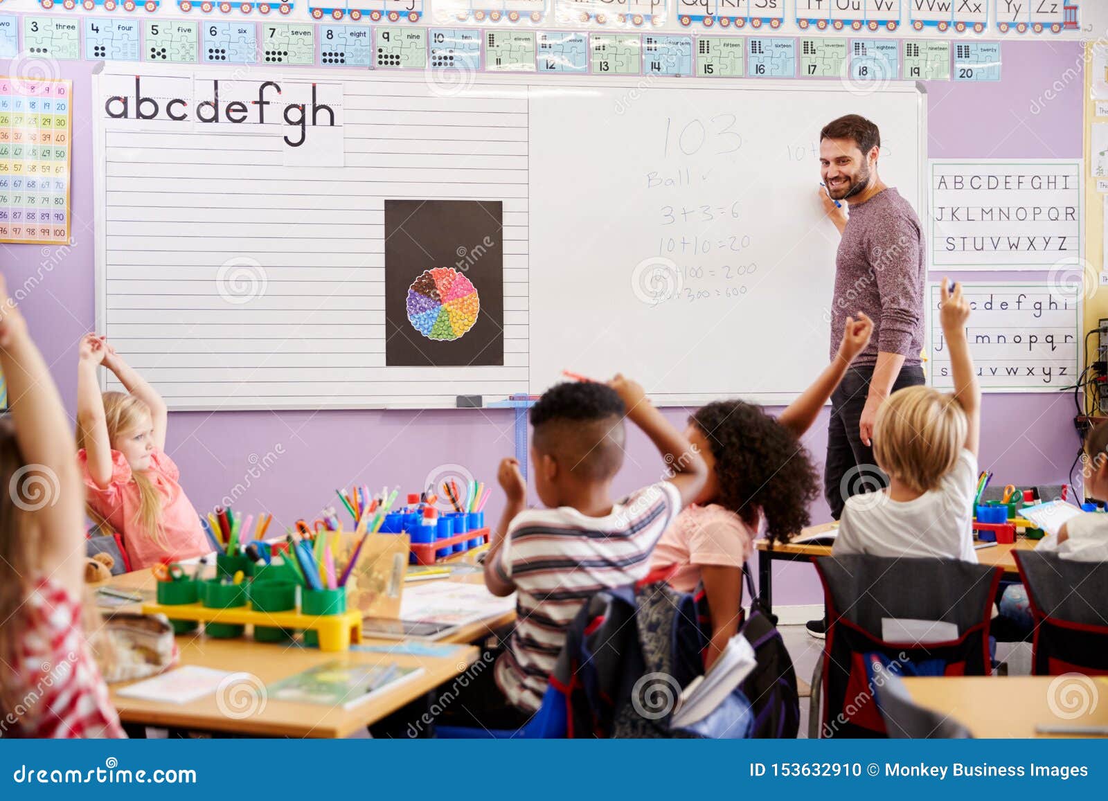 Pupils Raising Hands To Answer Question in Elementary School Maths ...