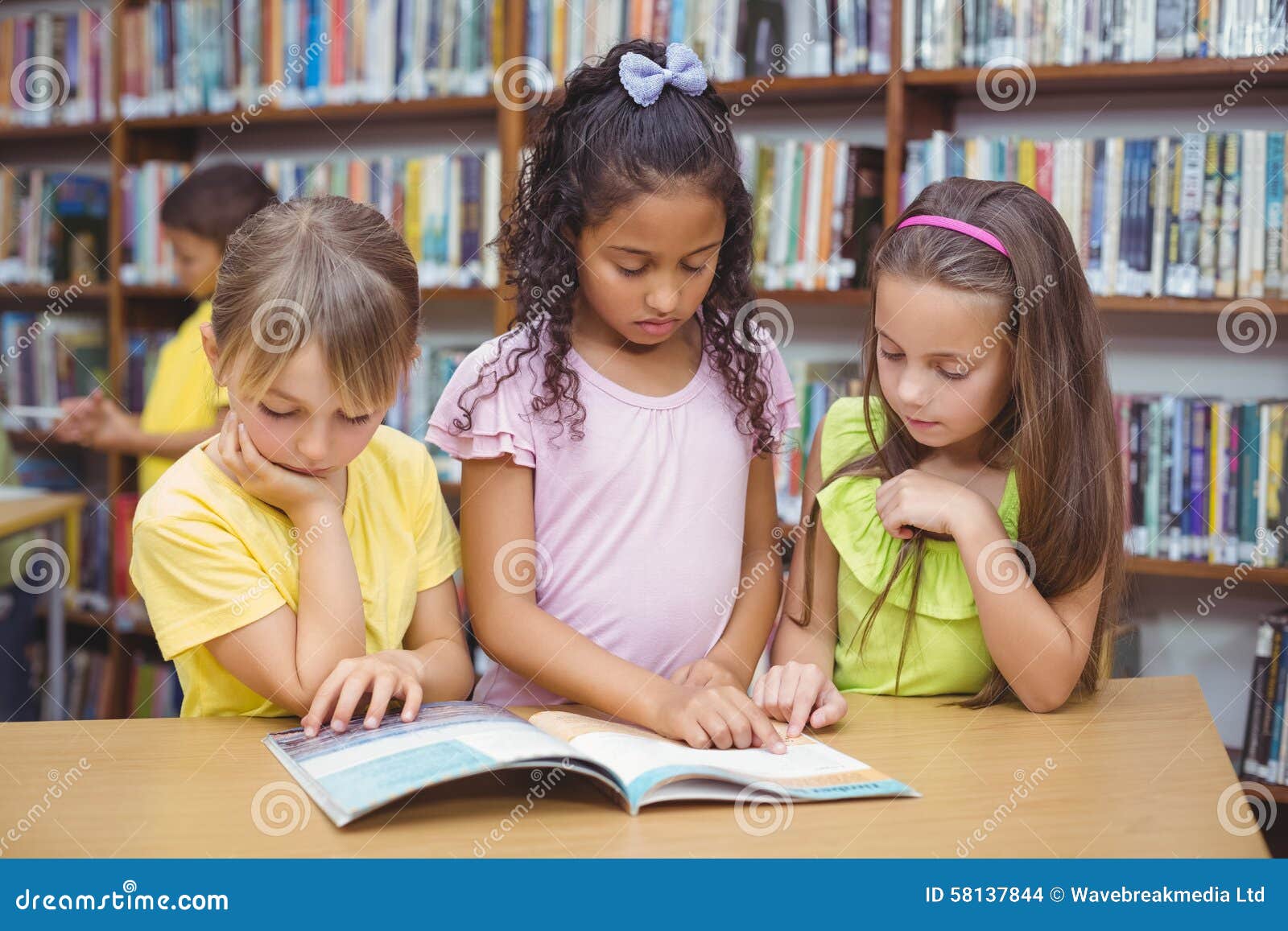 Pupils Reading Book Together in Library Stock Photo - Image of focused ...