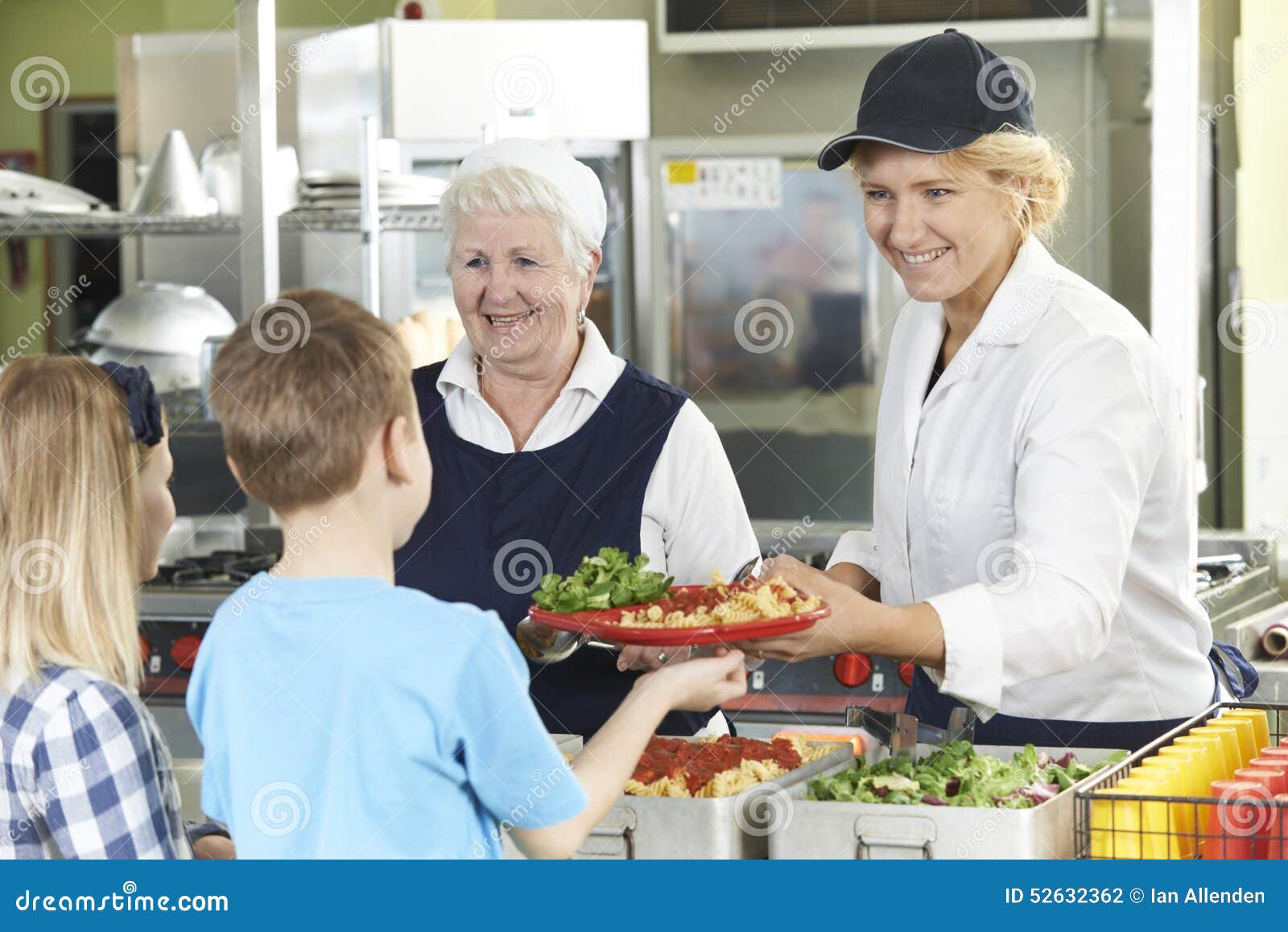 Pupils In School Cafeteria Being Served Lunch By Dinner Ladies Stock ...