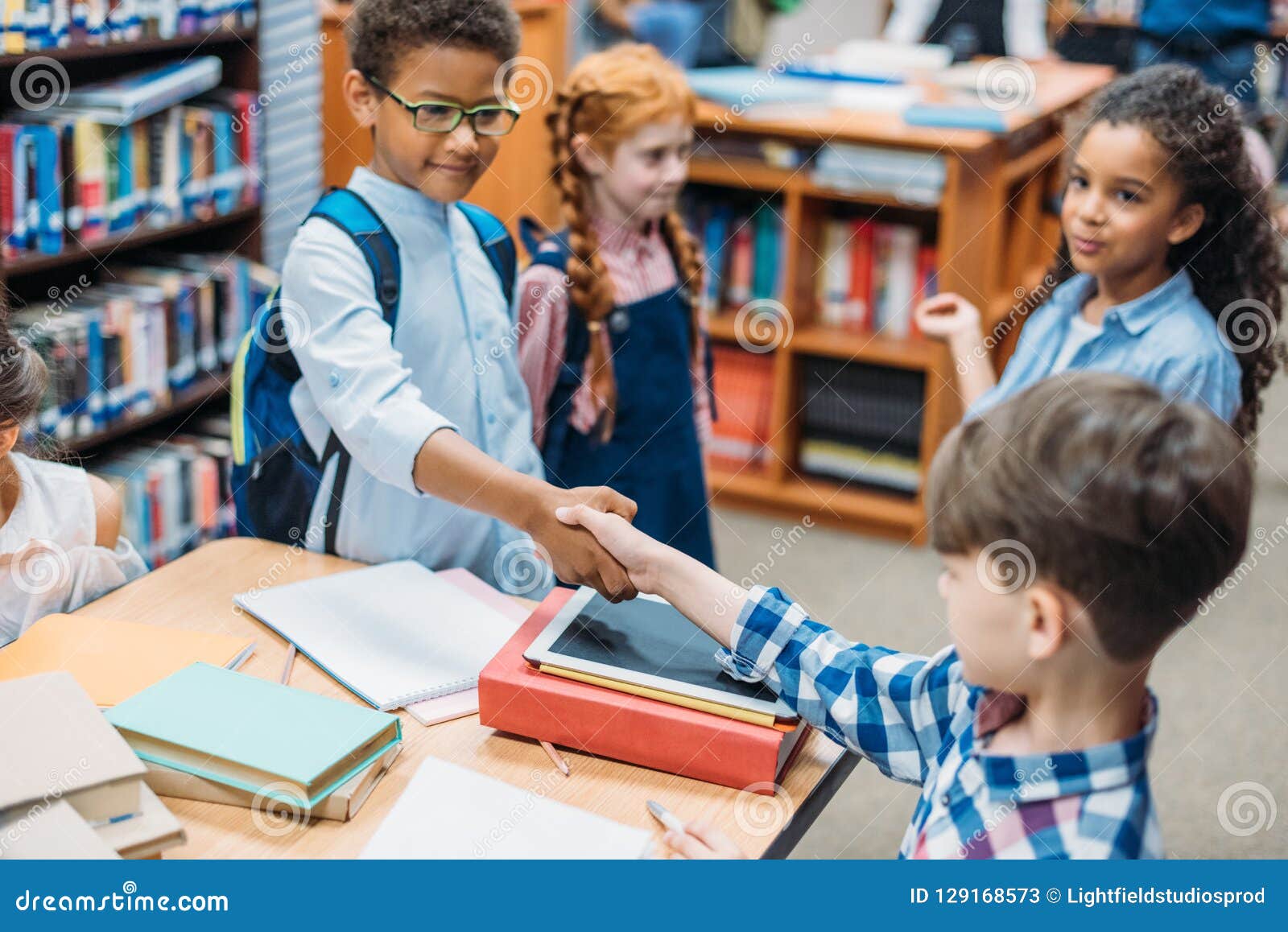 Pupils shaking hands stock image. Image of children - 129168573