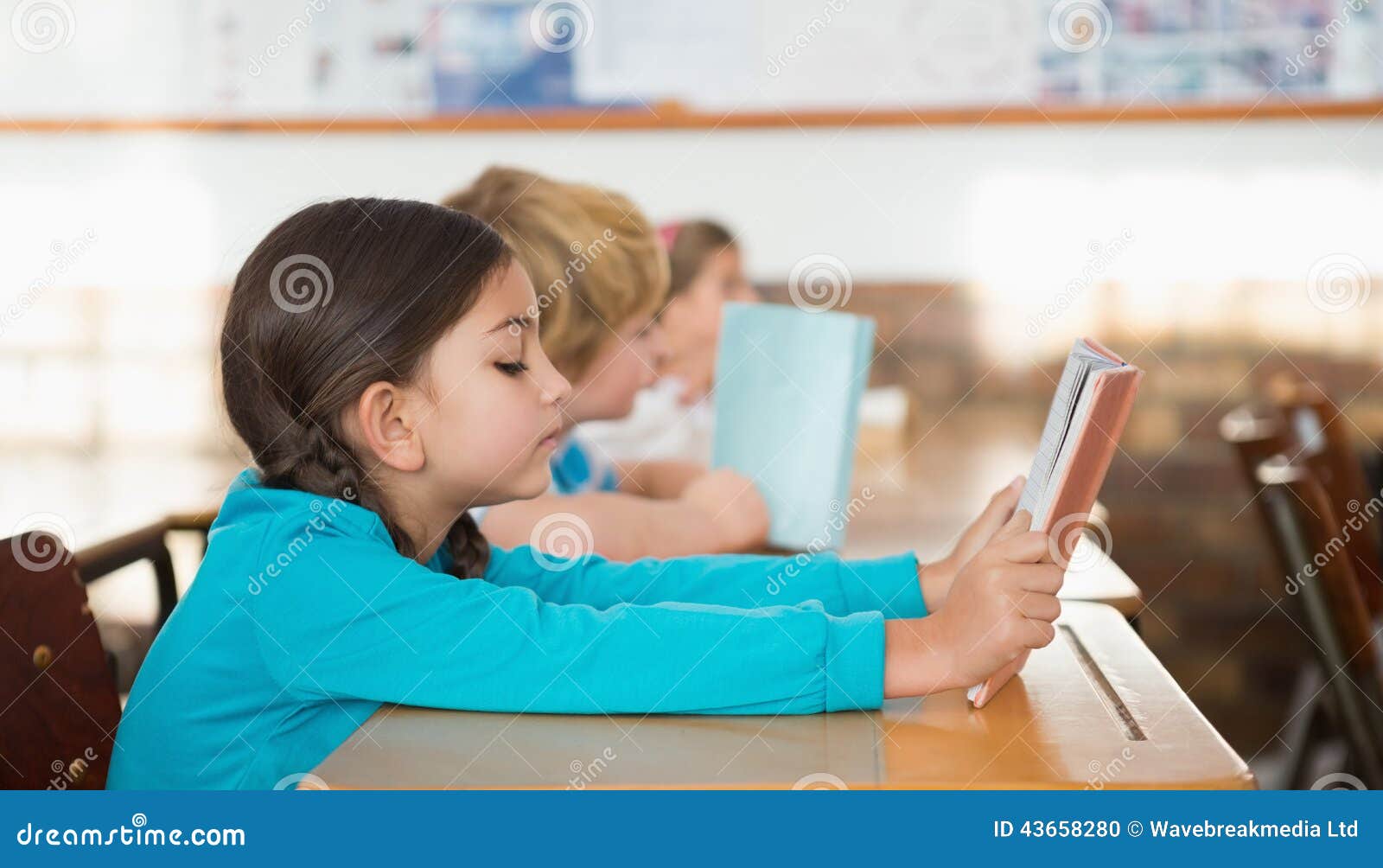 Pupils Sitting in Classroom Reading Books Stock Photo - Image of ...