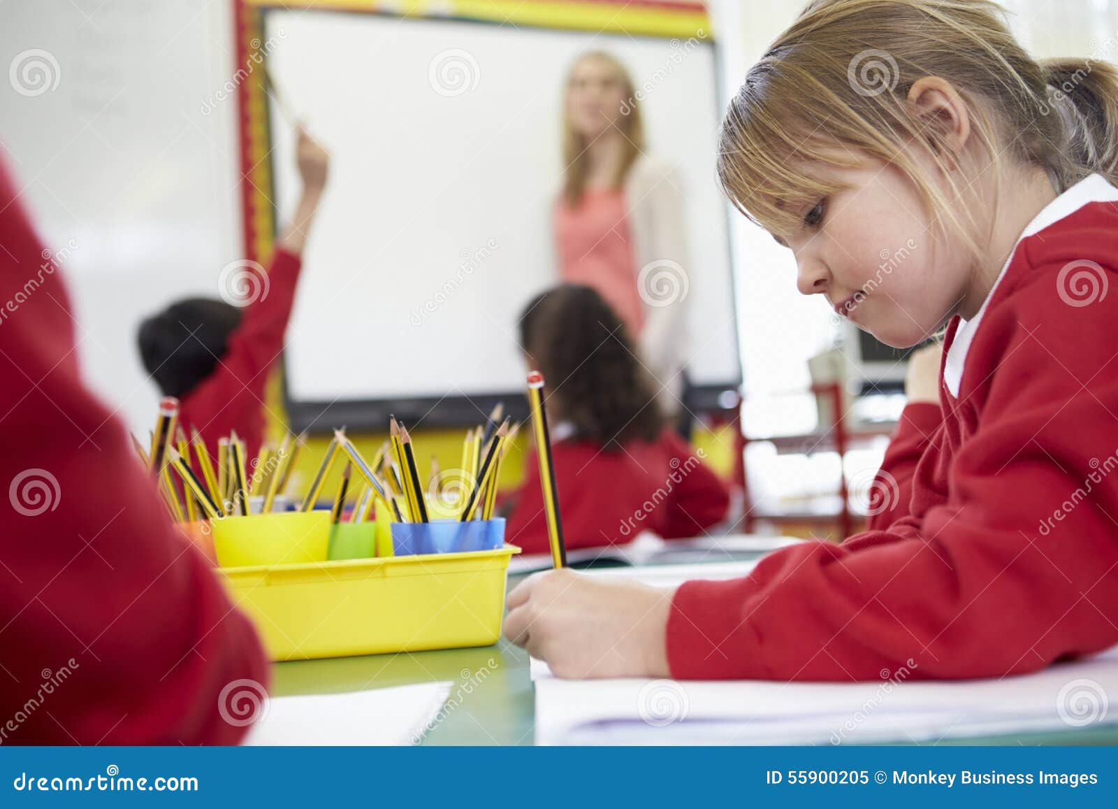 Pupils Sitting at Table As Teacher Stands by Whiteboard Stock Image ...