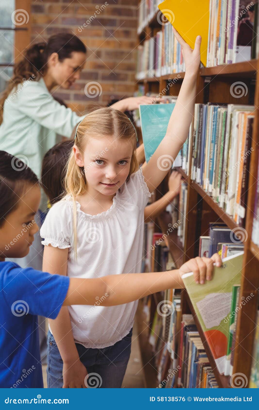 Pupils Taking Books from Shelf in Library Stock Photo - Image of female ...