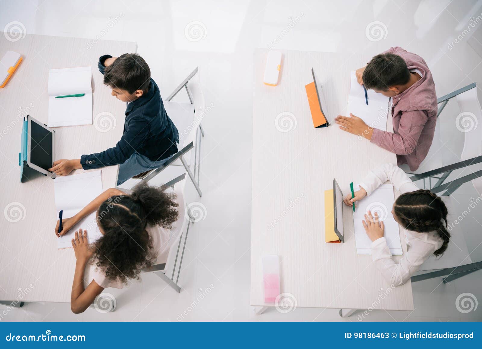 Pupils Using Digital Tablets while Sitting at Desks in Classroom Stock ...