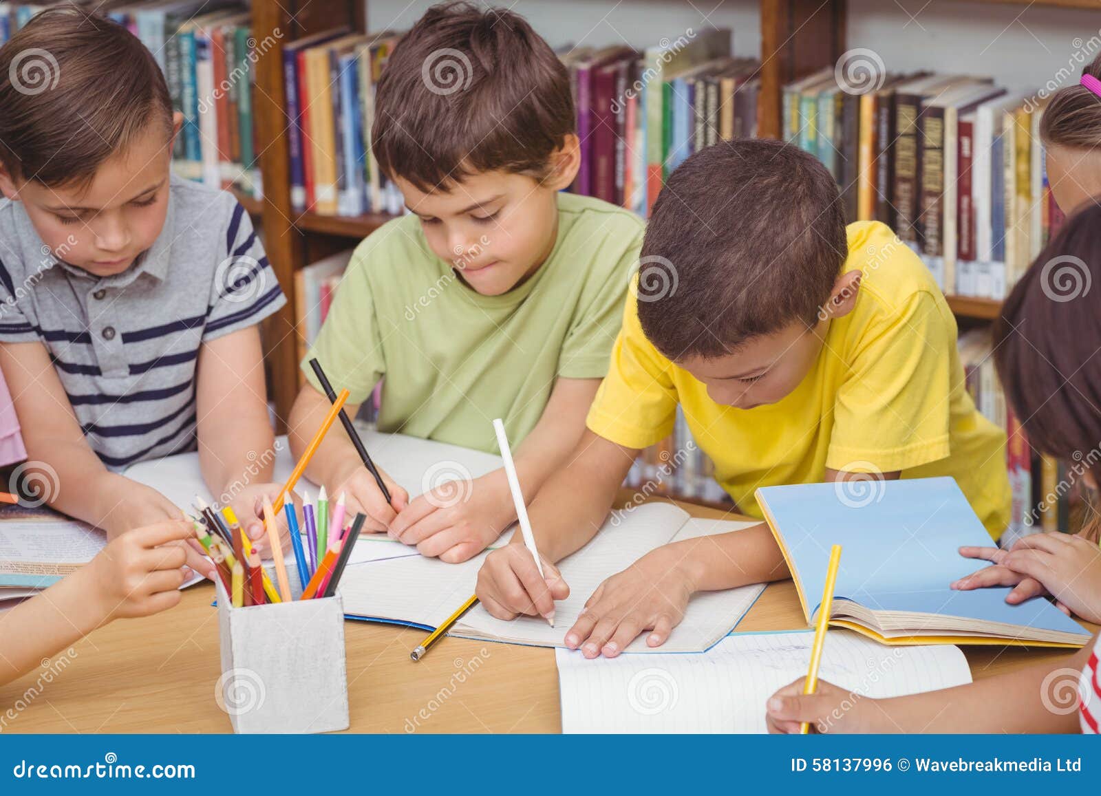 Pupils Working Together at Desk in Library Stock Photo - Image of ...