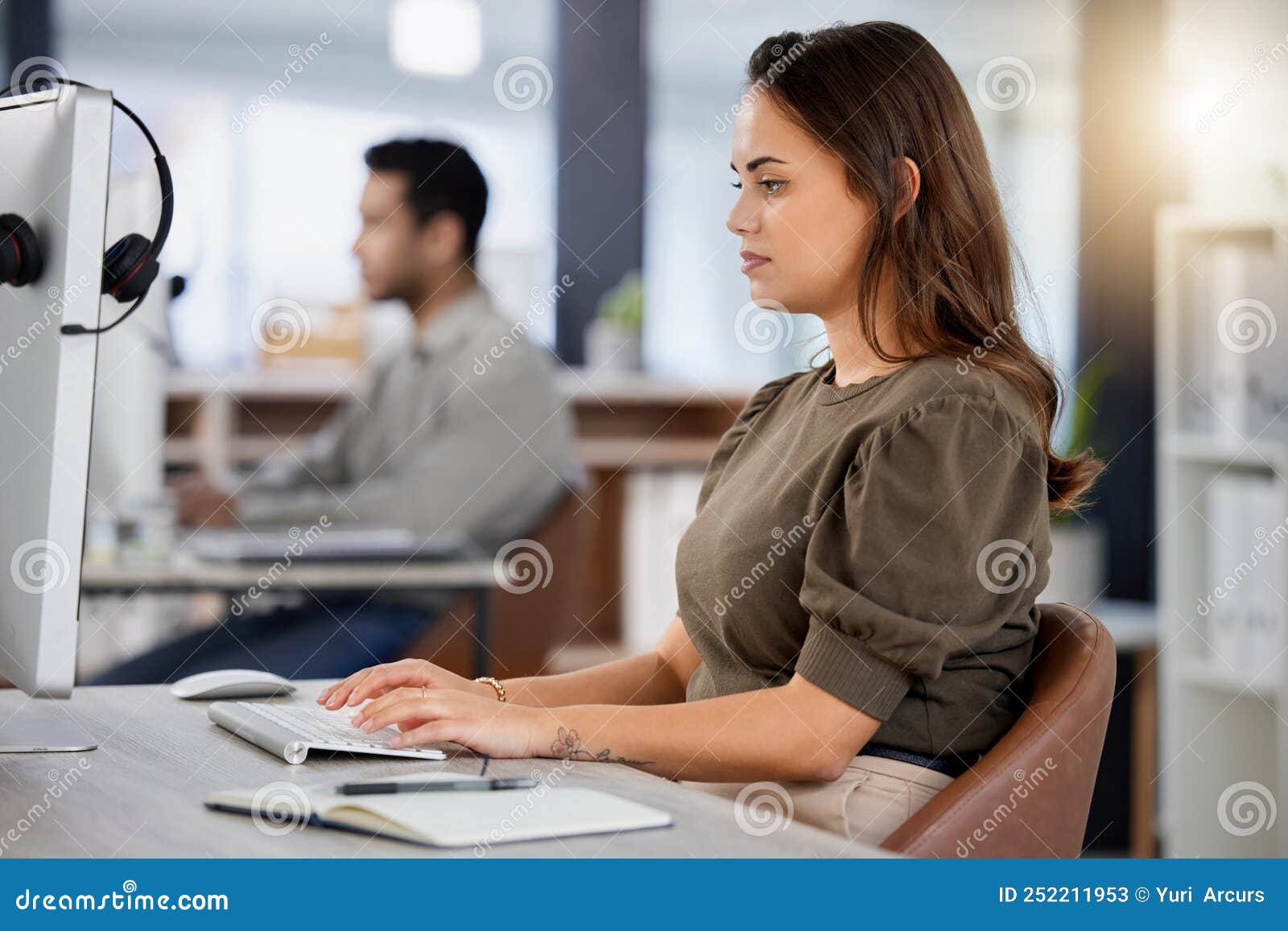 Pushing through the Day. a Young Female Call Center Agent Using a ...