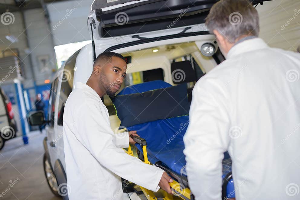 Putting bed in ambulance stock photo. Image of transfer - 84259708