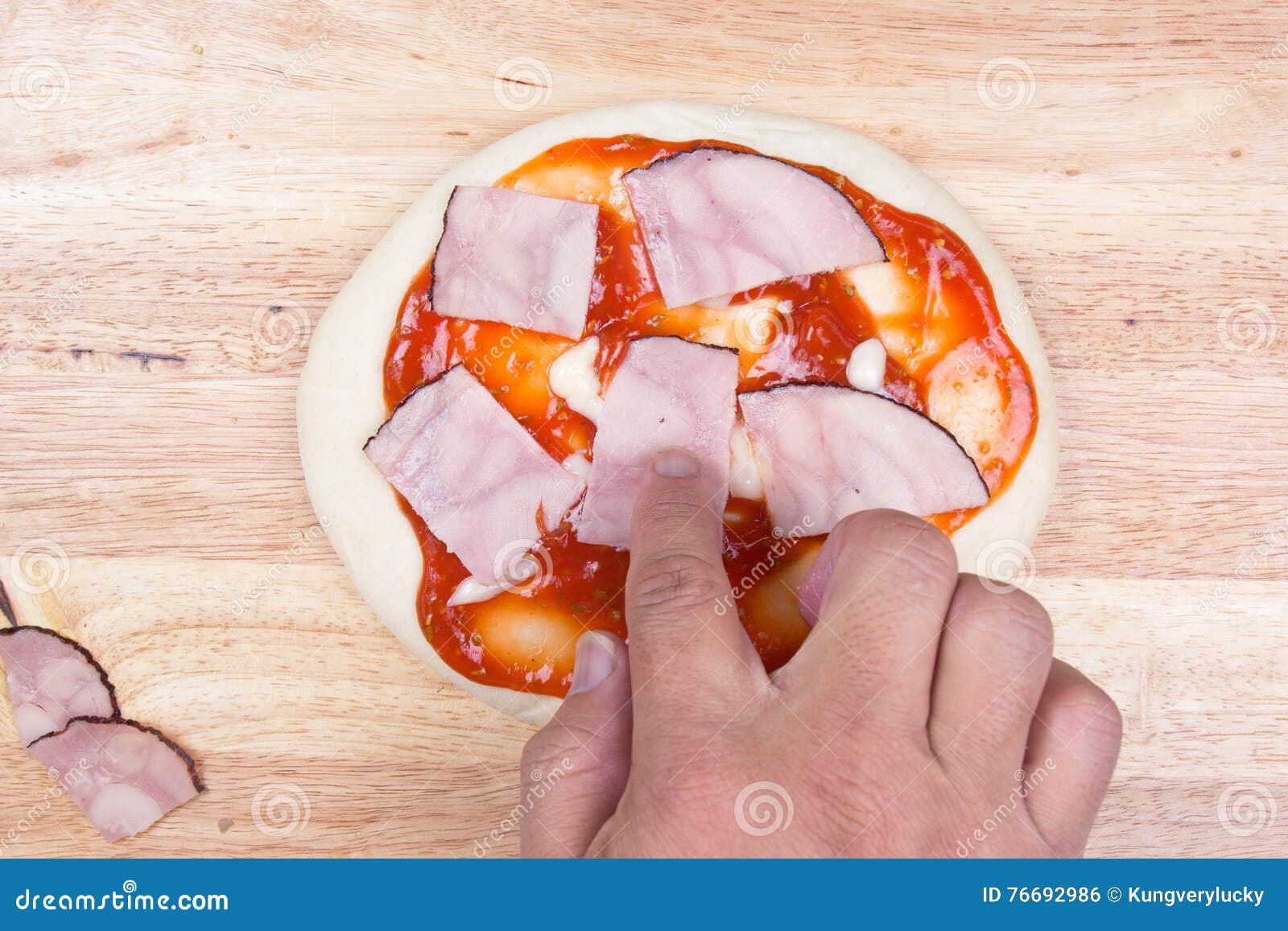 Putting Ham on pizza crust stock photo. Image of pizza - 76692986