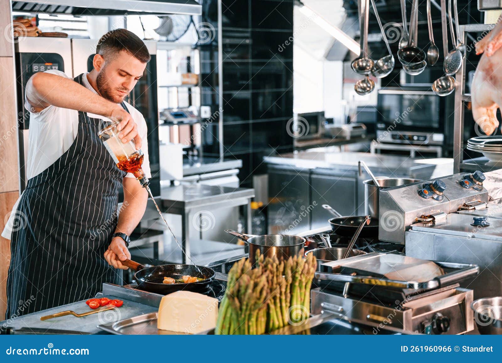 Putting Oil. Chef is on the Kitchen Preparing Food Stock Photo - Image ...