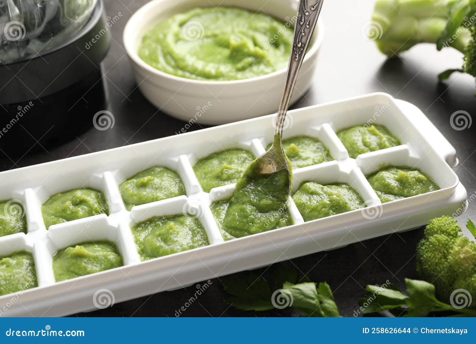 Putting Puree with Spoon into Ice Cube Tray on Table, Closeup. Ready ...