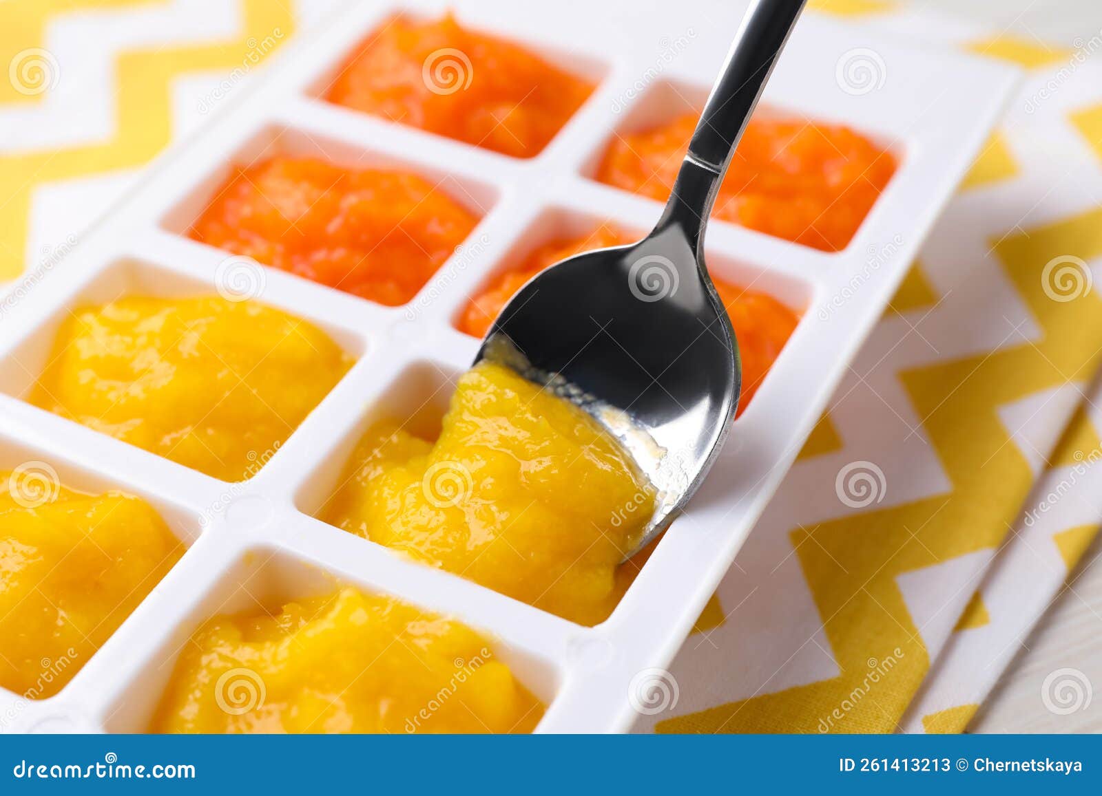 Putting Puree with Spoon into Ice Cube Tray on Table, Closeup. Ready ...