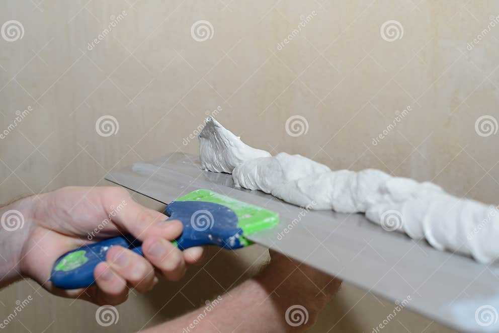 Puttying the Wall with Plaster Putty Using a Wide Spatula Stock Photo ...