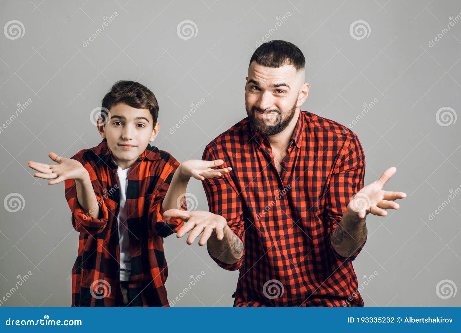 Puzzled Handsome Man and His Son Standing with Spread Hands in Clueless ...