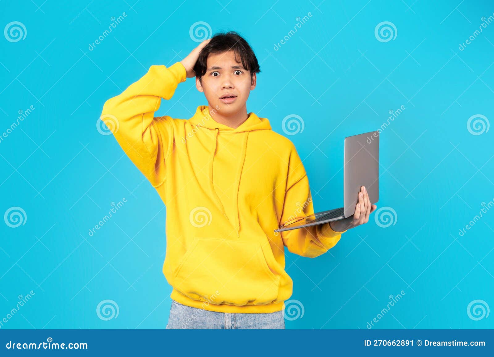 Puzzled Japanese Teen Guy Holding Laptop Touching Head, Blue Background ...