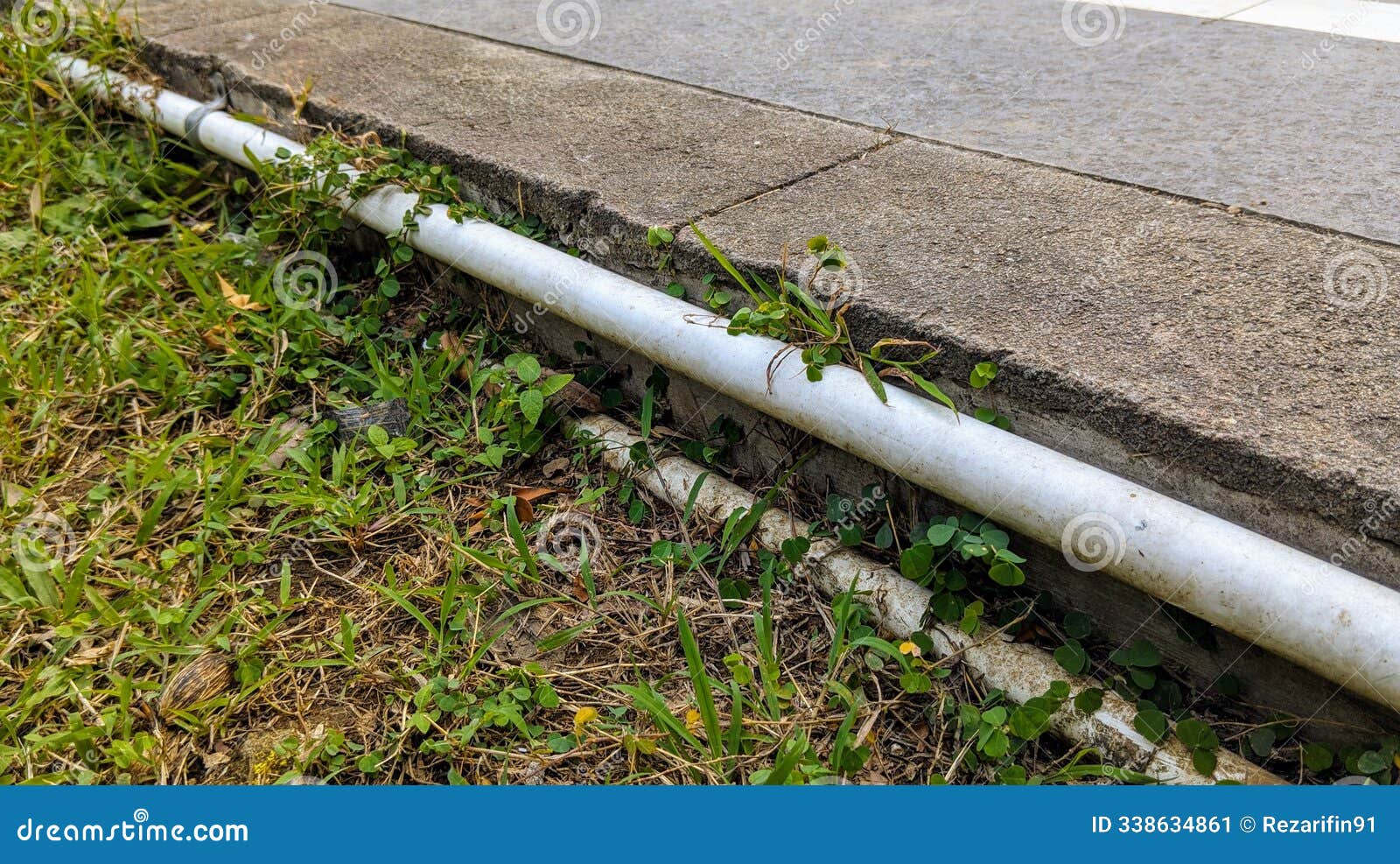 PVC Pipe Located on the Ground Near a Concrete Sidewalk, with a Small ...