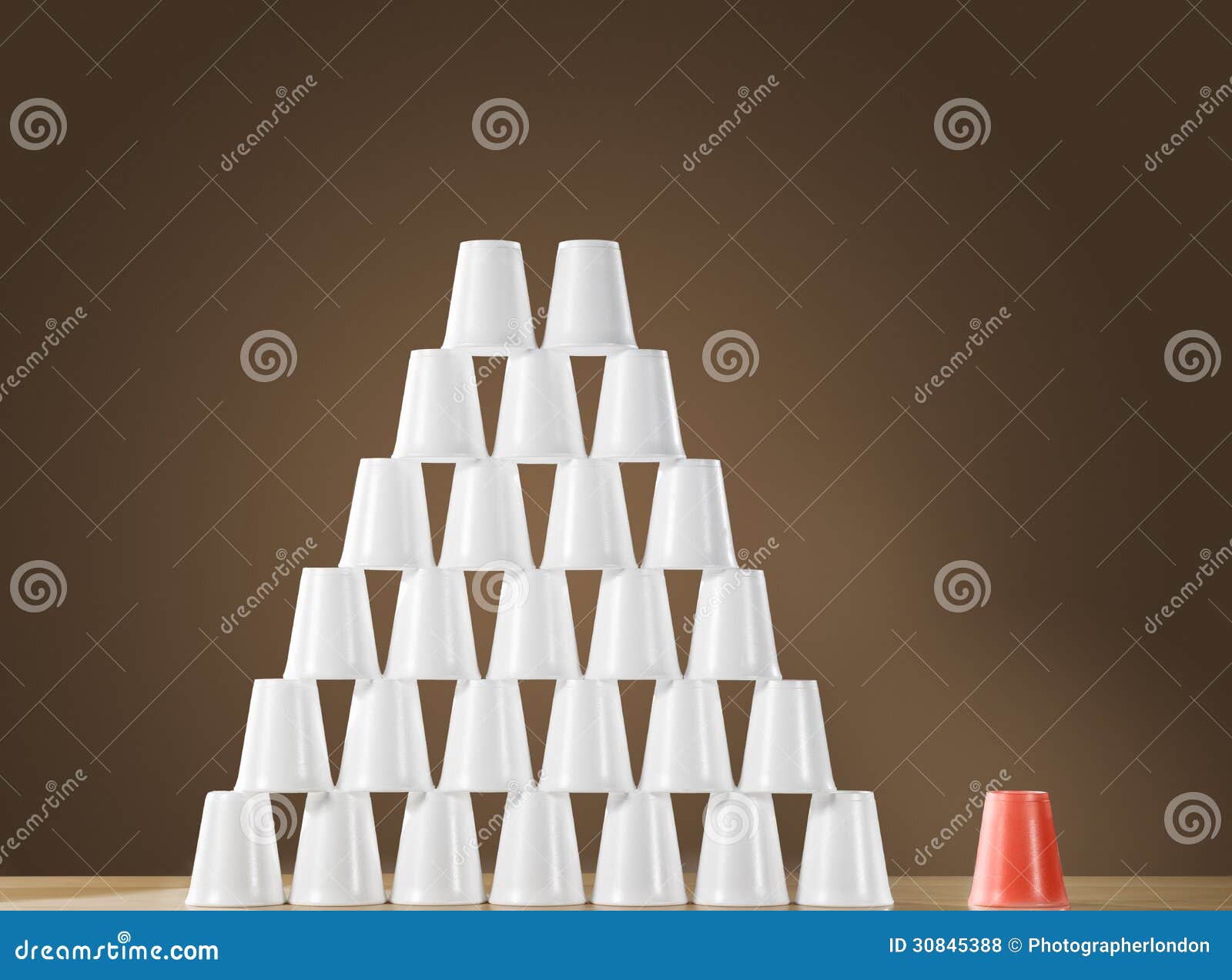 Pyramid of White Plastic Cups on Table Next To Single Red Cup Stock ...