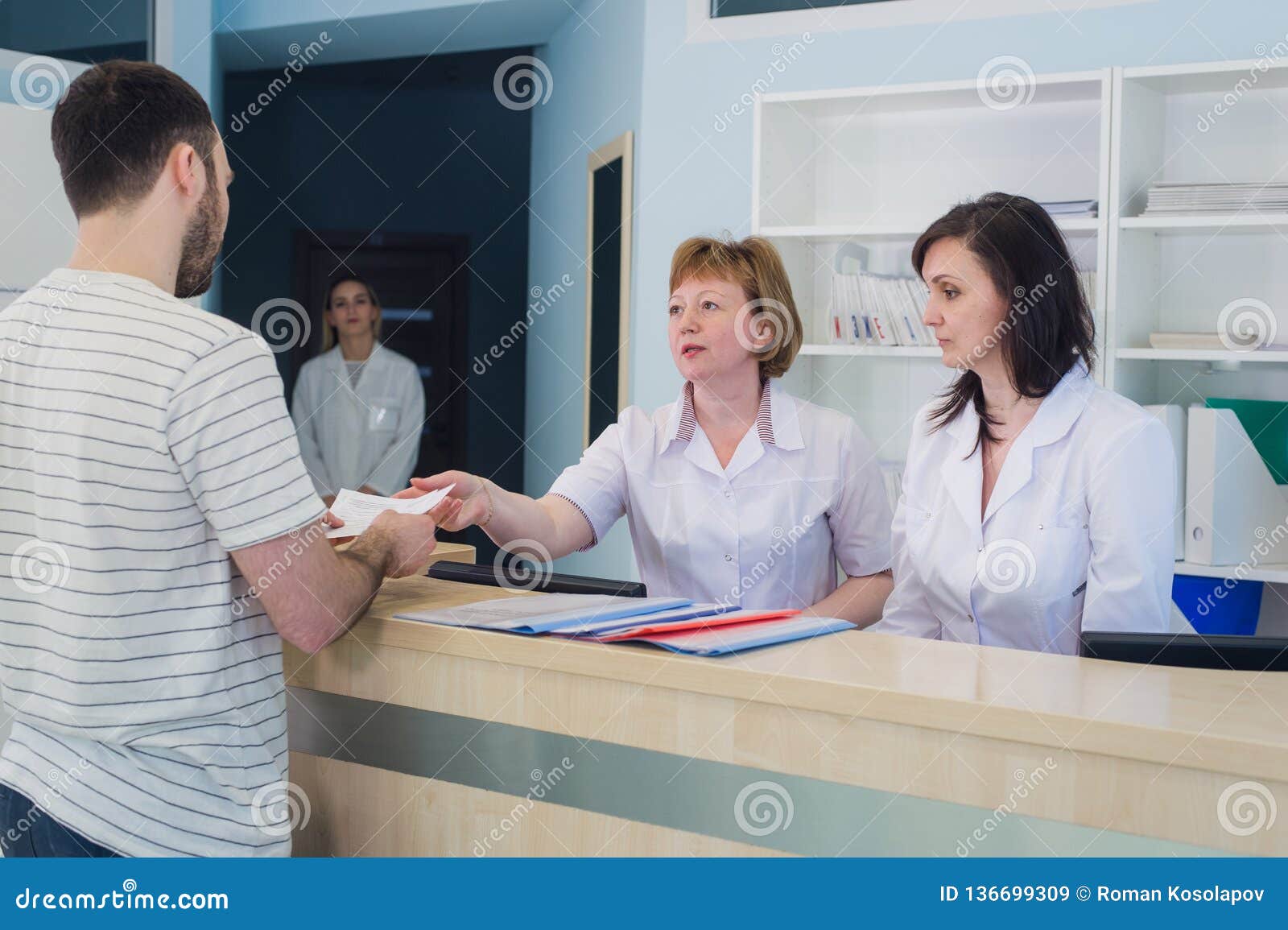 Qualified Smiling Doctors Working with Client at Reception Desk in ...