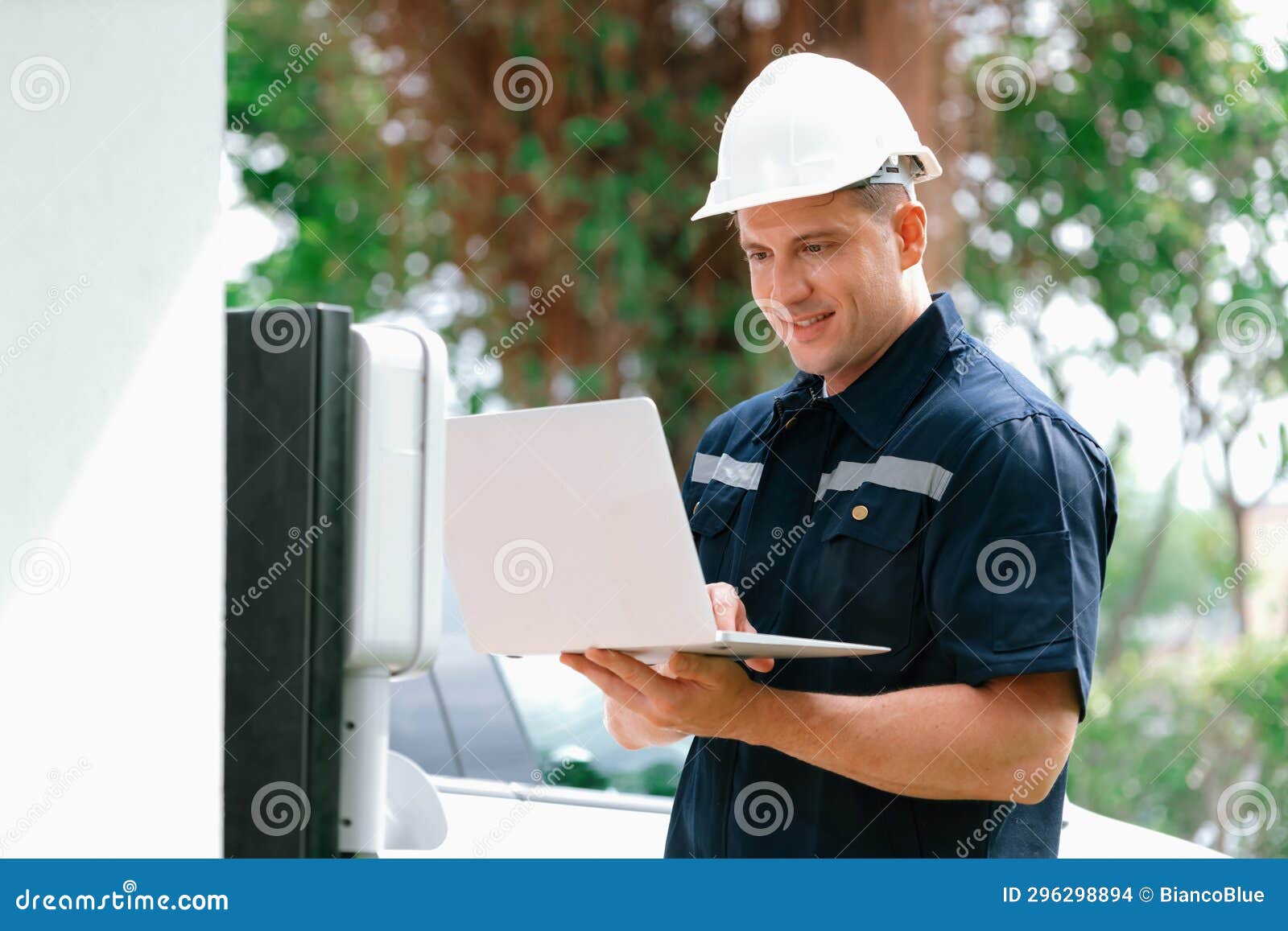 Qualified Technician Working with Laptop for Home EV Station ...