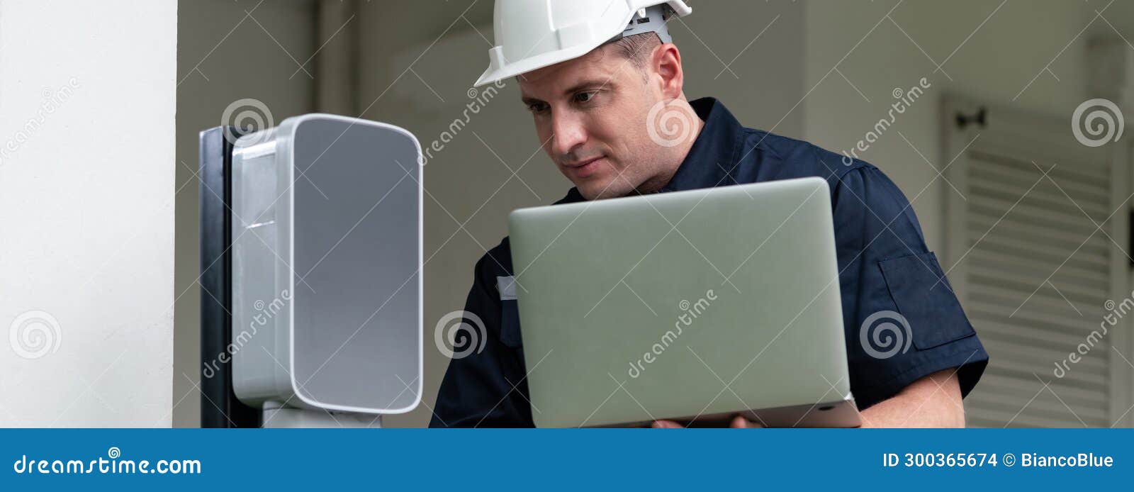 Qualified Technician Working with Laptop for Home EV Station ...