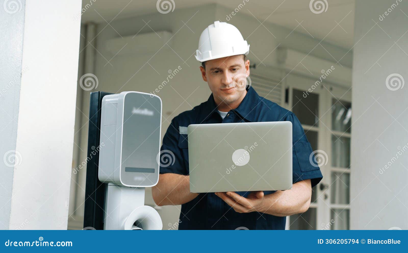 Qualified Technician Working with Laptop for Home EV Station ...
