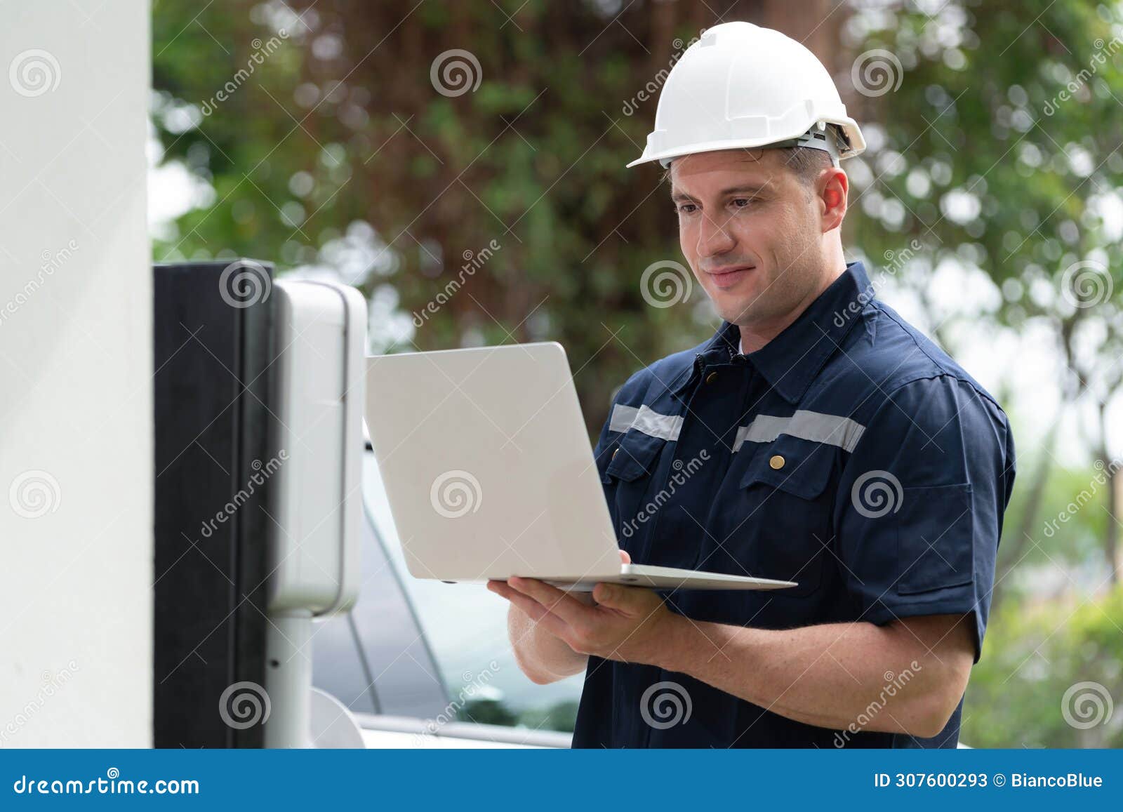 Qualified Technician Working with Laptop for Home EV Station ...