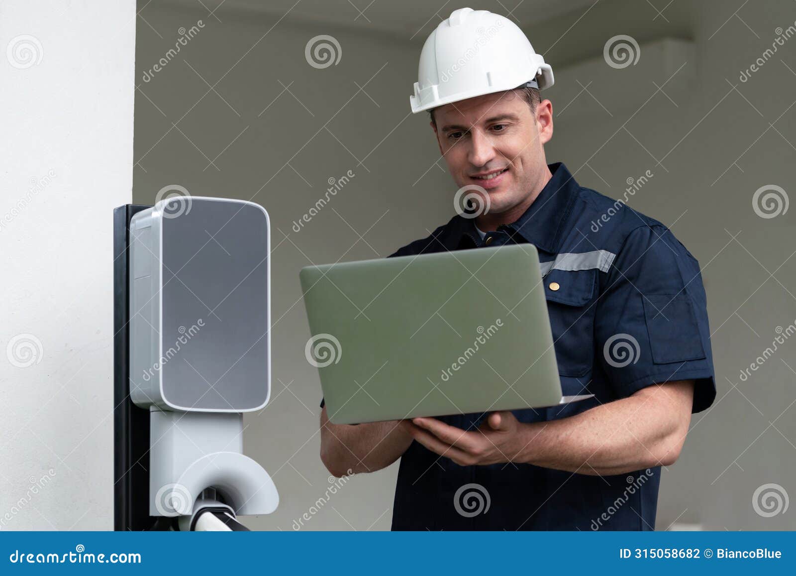 Qualified Technician Working with Laptop for Home EV Station ...