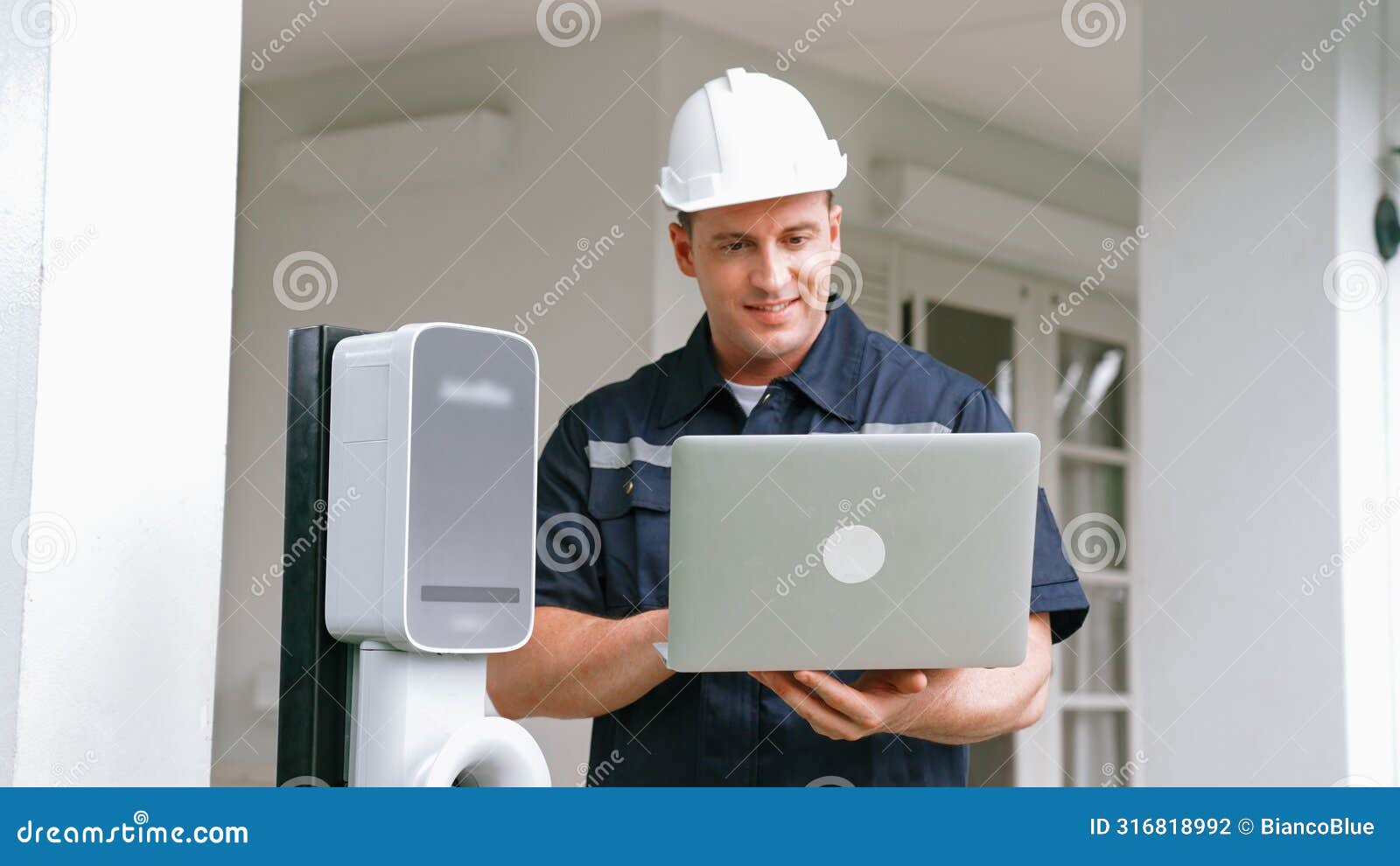 Qualified Technician Working with Laptop for Home EV Station ...