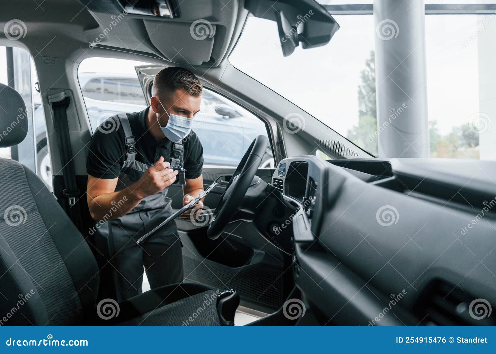 Quality Control. Man in Uniform is Working in the Autosalon at Daytime ...