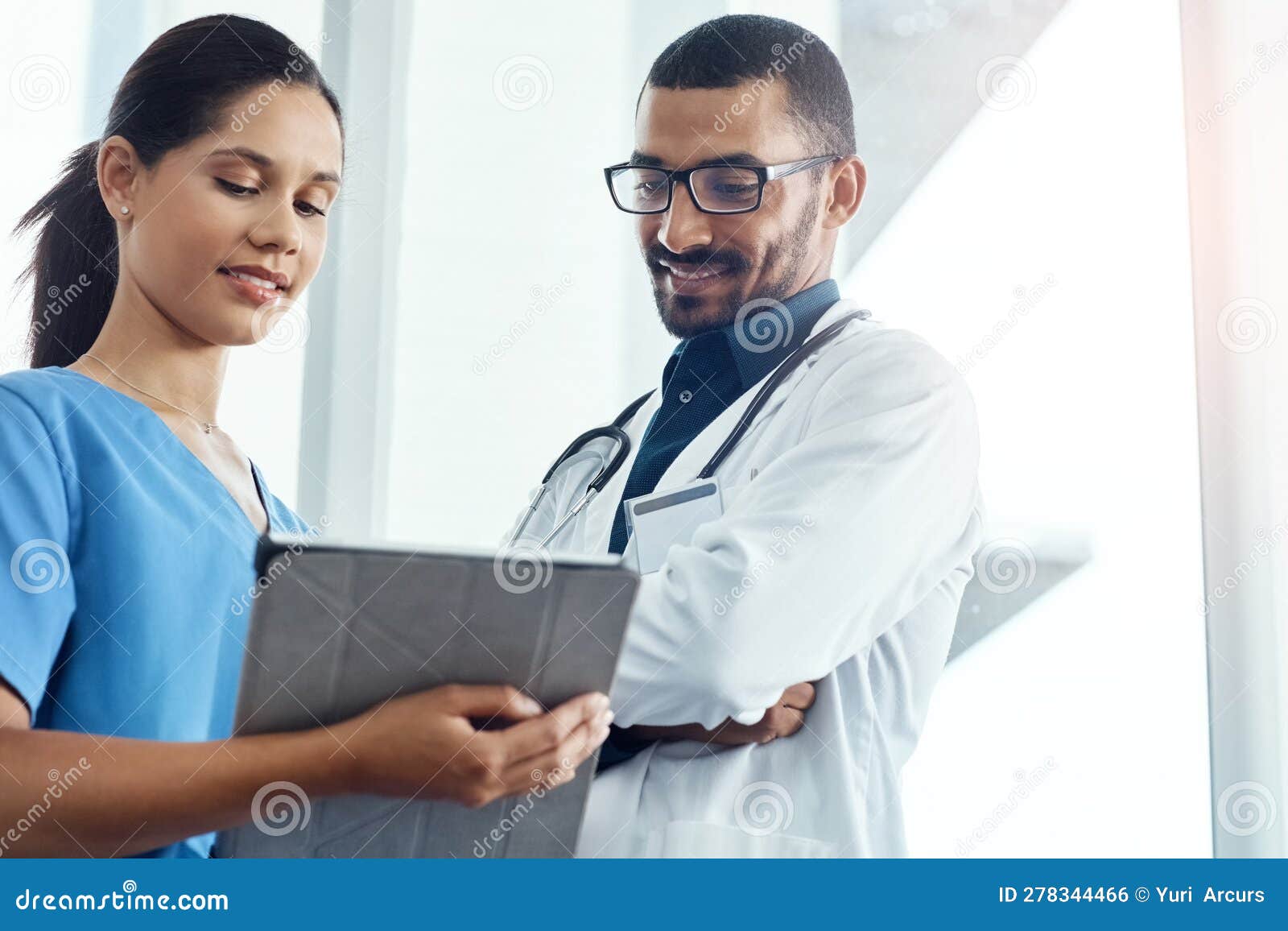 Quality Healthcare Driven by Teamwork. Two Young Doctors Using a ...