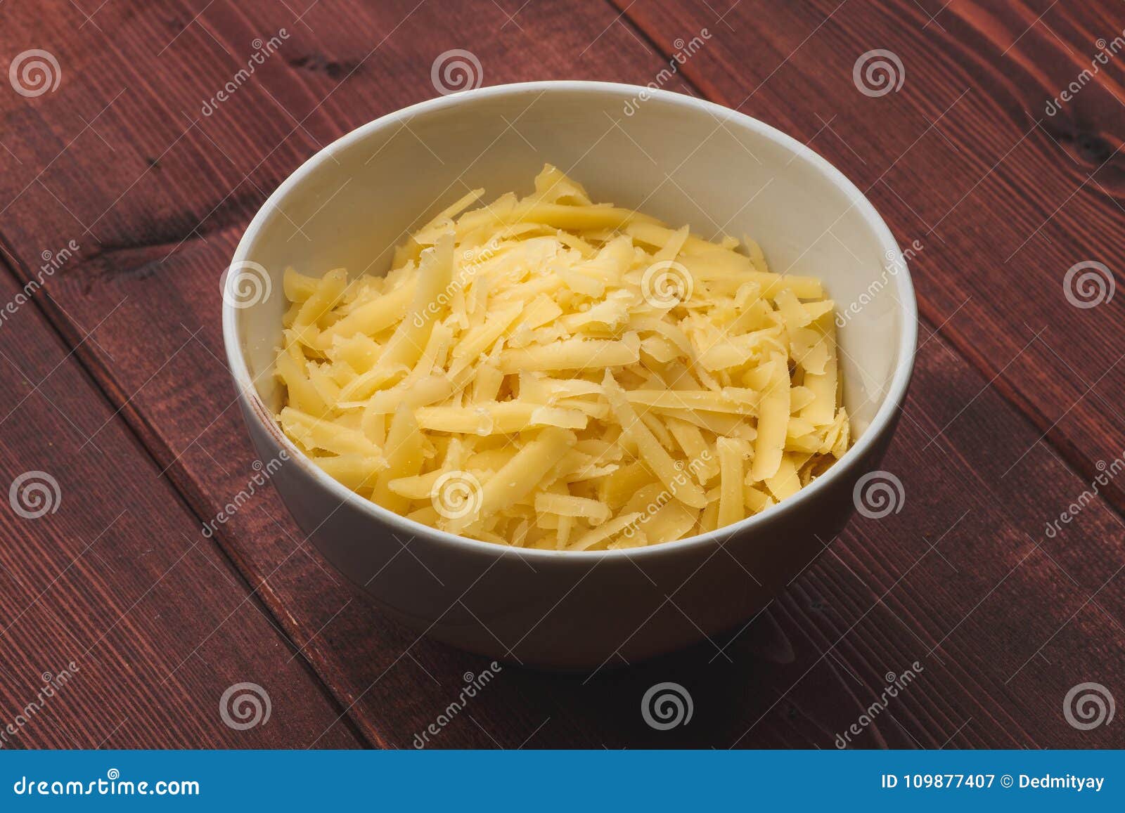 Queso Rallado En El Cuenco Blanco En La Tabla De Madera Imagen de ...