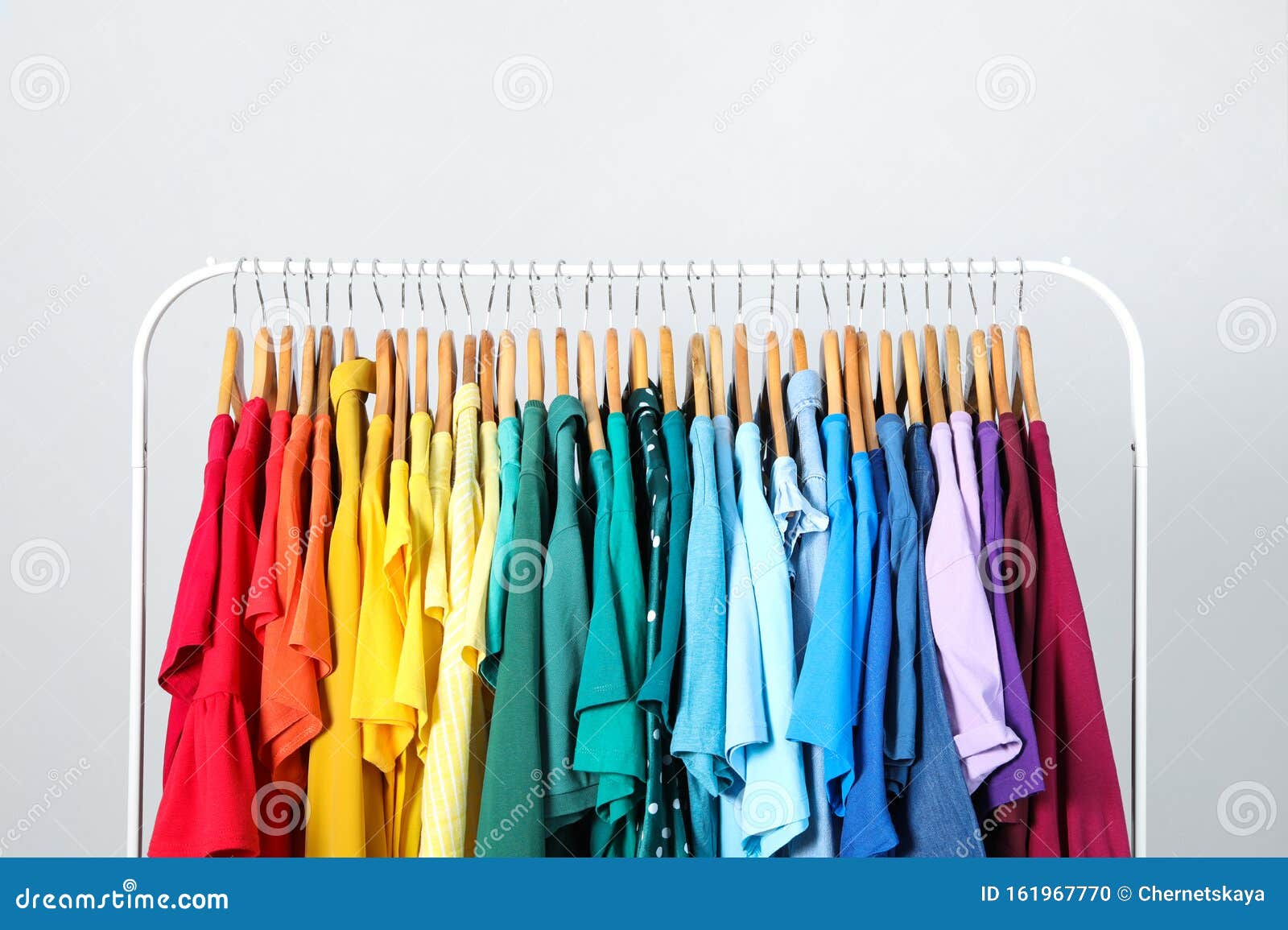 Rack with Bright Clothes on Blue Background. Rainbow Colors Stock Photo ...