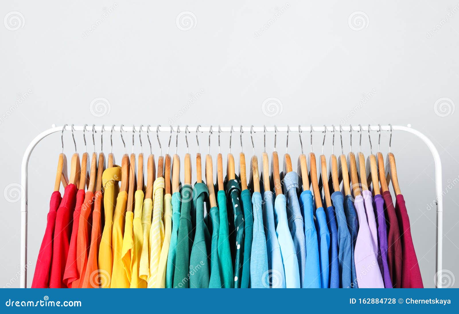 Rack with Bright Clothes on Light Blue. Rainbow Colors Stock Photo ...