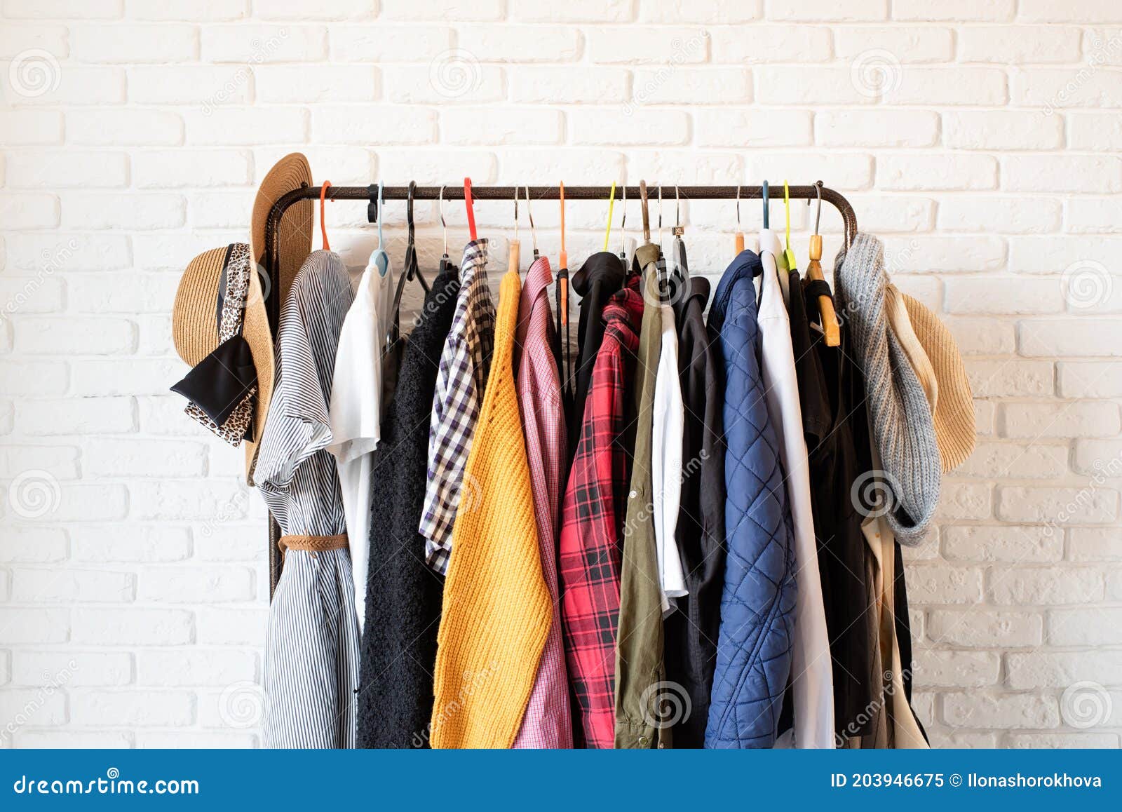 Rack with Colorful Clothes on Hangers Over White Brick Wall Background ...