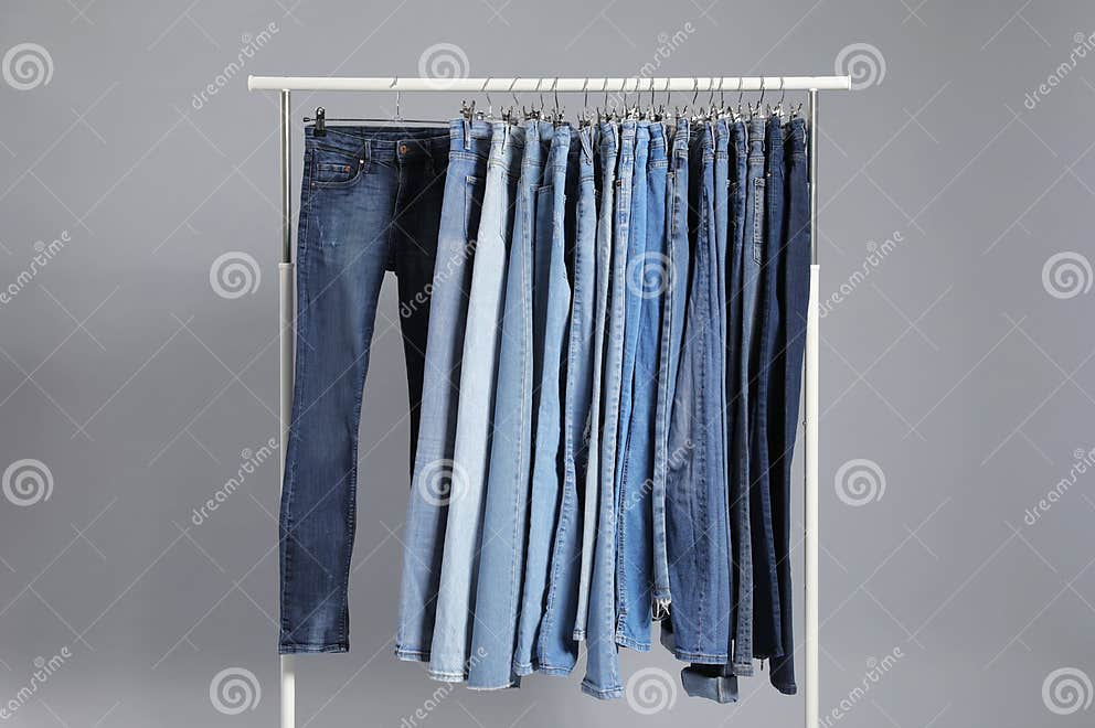 Rack with Different Jeans on Grey Background Stock Photo - Image of ...