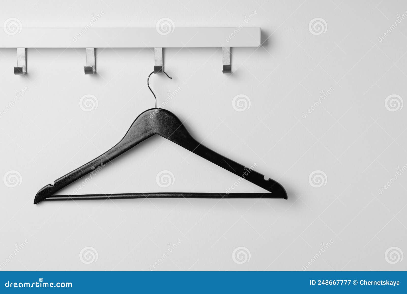 Rack with Empty Black Clothes Hanger on White Wall Stock Image - Image ...